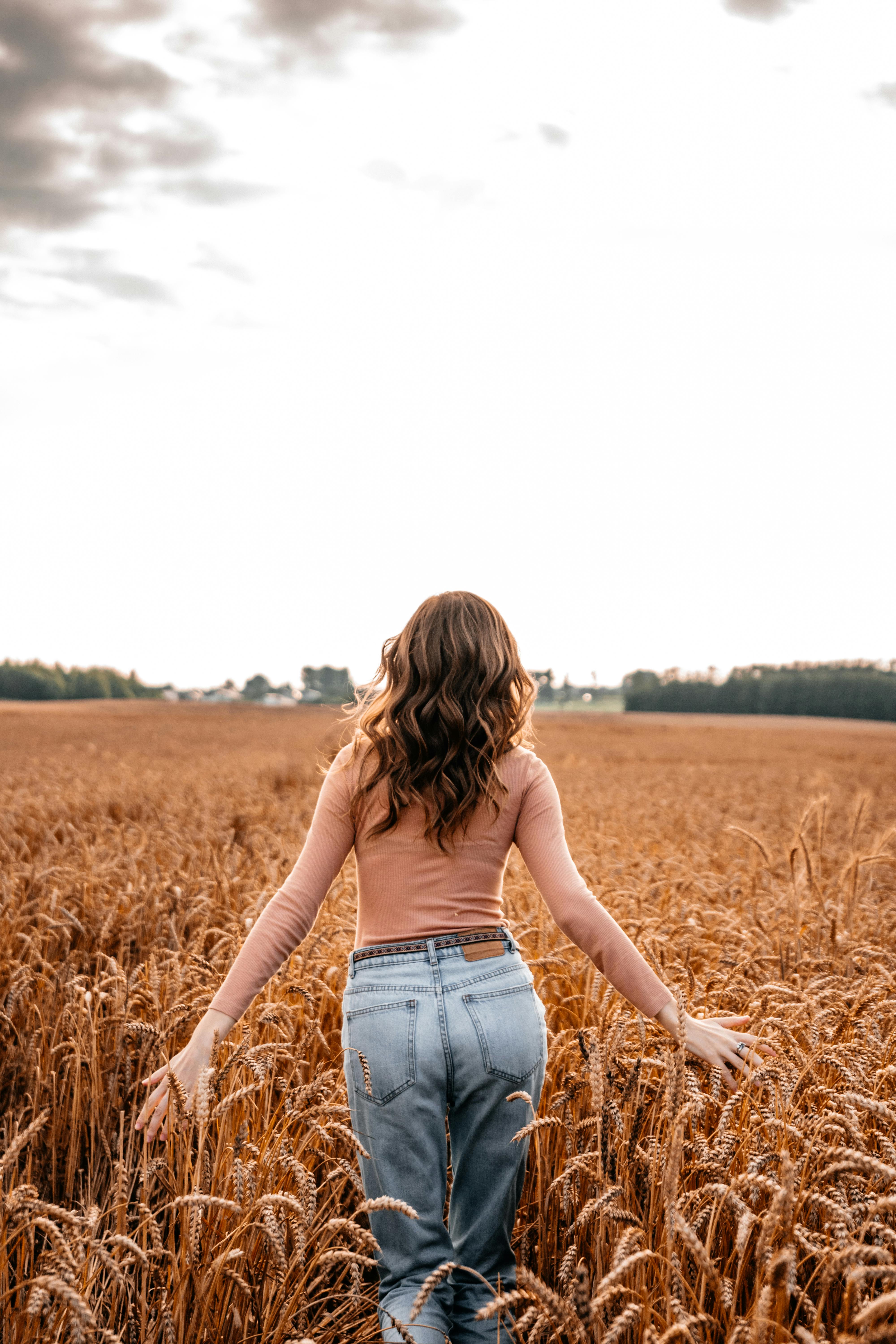 Woman Walking Through Field of Wheat · Free Stock Photo