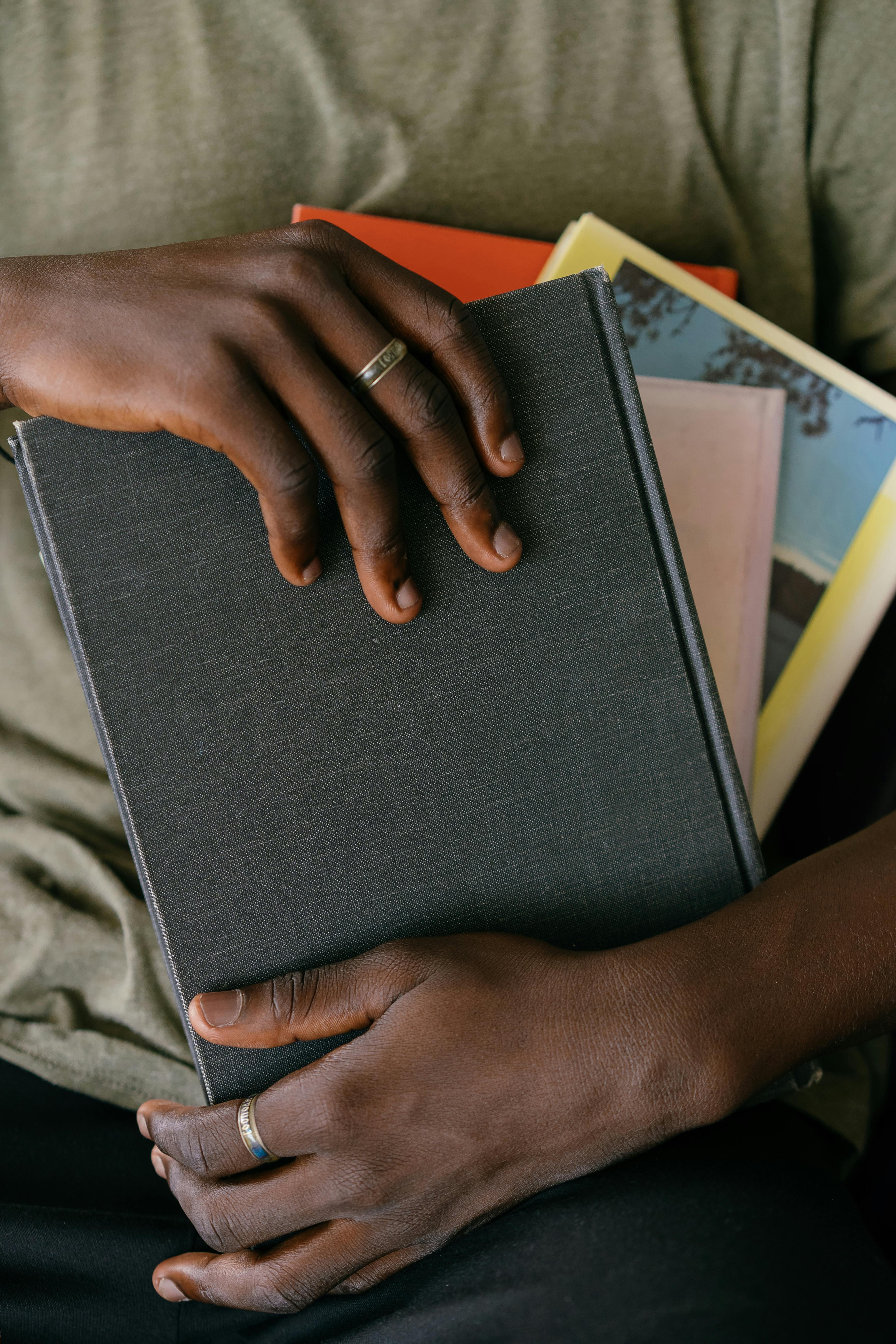 Close-Up Shot of a Person Holding Books · Free Stock Photo