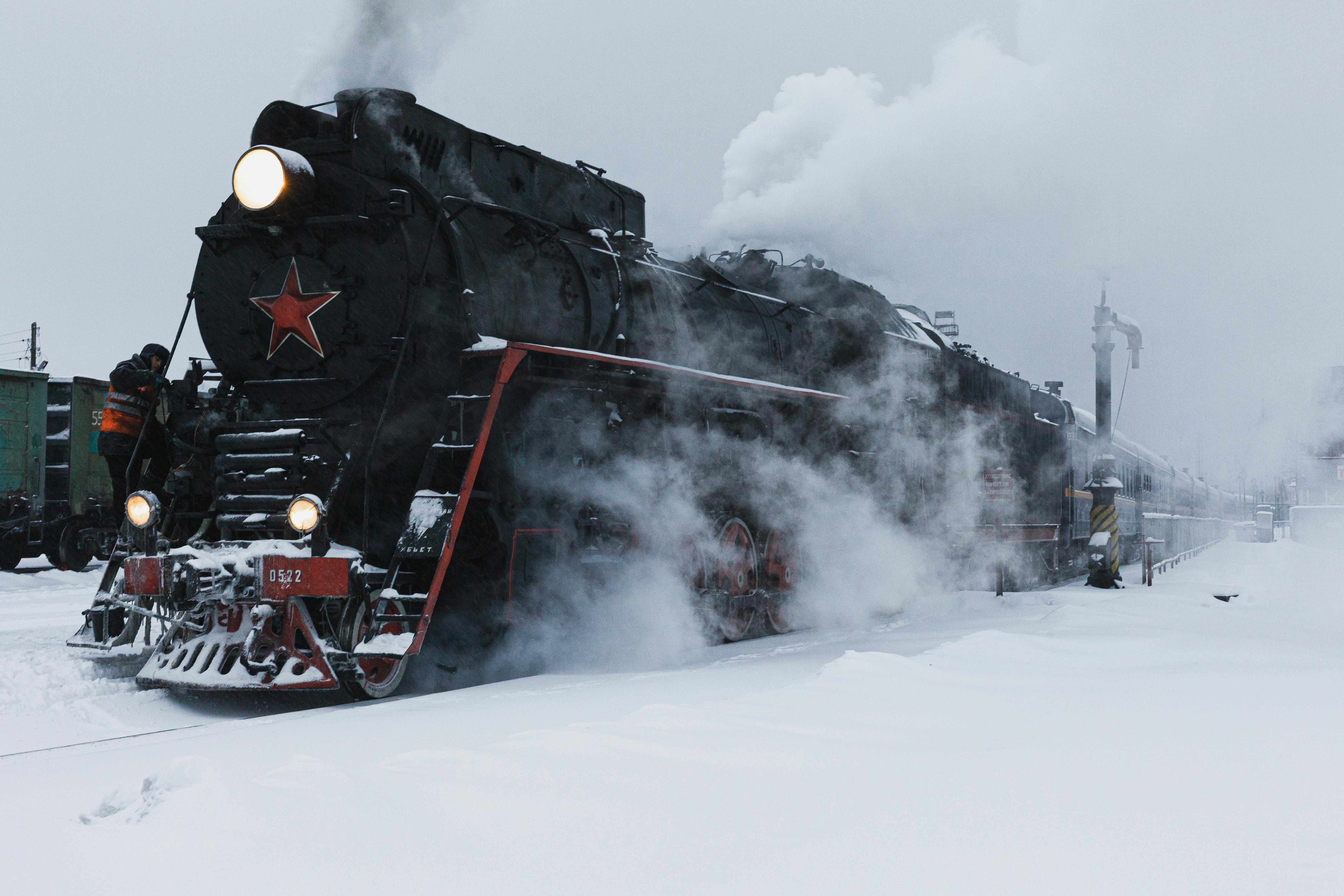 A Train Running on Snow Covered Rail Tracks · Free Stock Photo