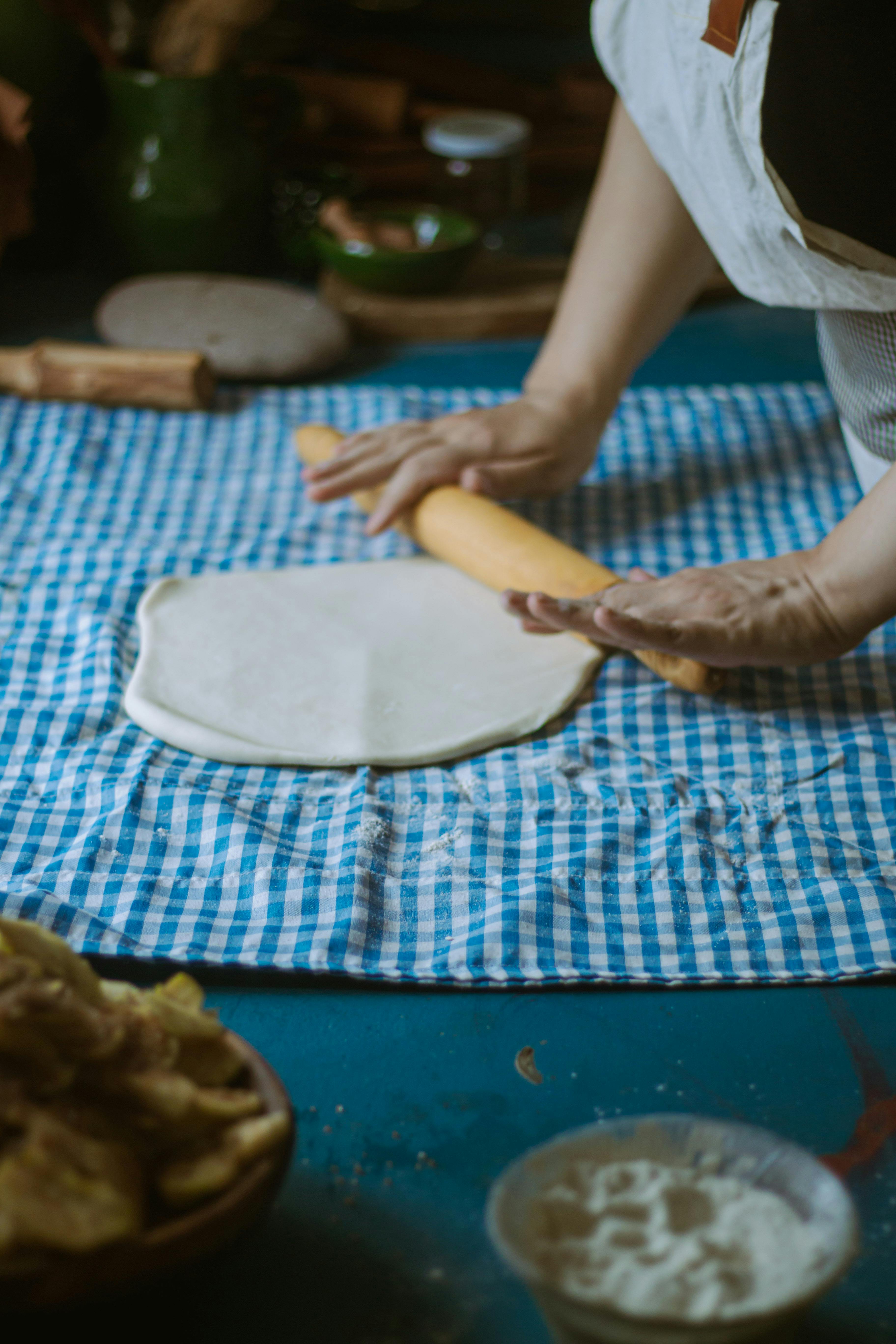 A Person Using Rolling Pin on a Dough · Free Stock Photo
