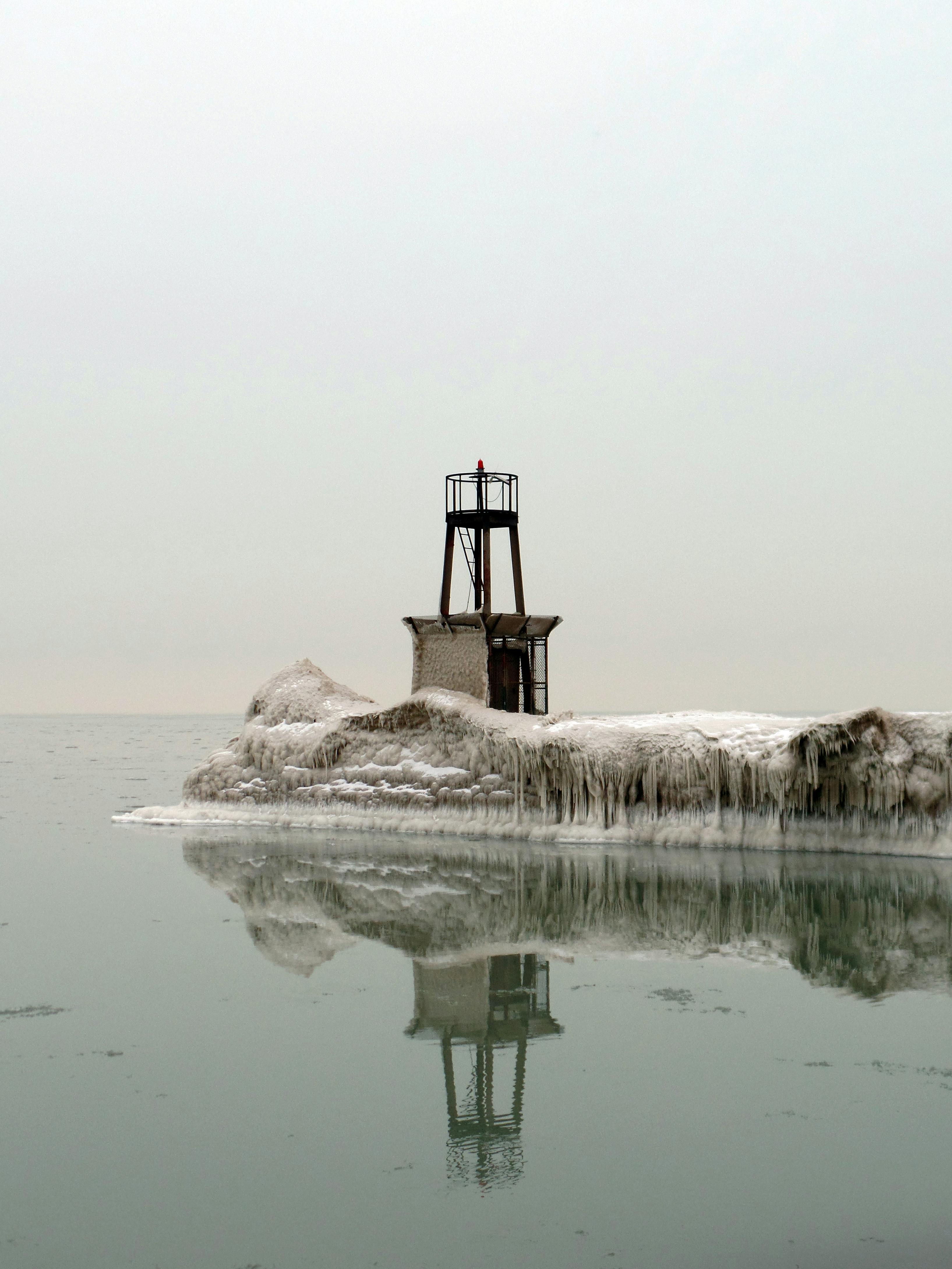 Brown and Black Lighthouse on White Rock Formation on Sea Water · Free ...
