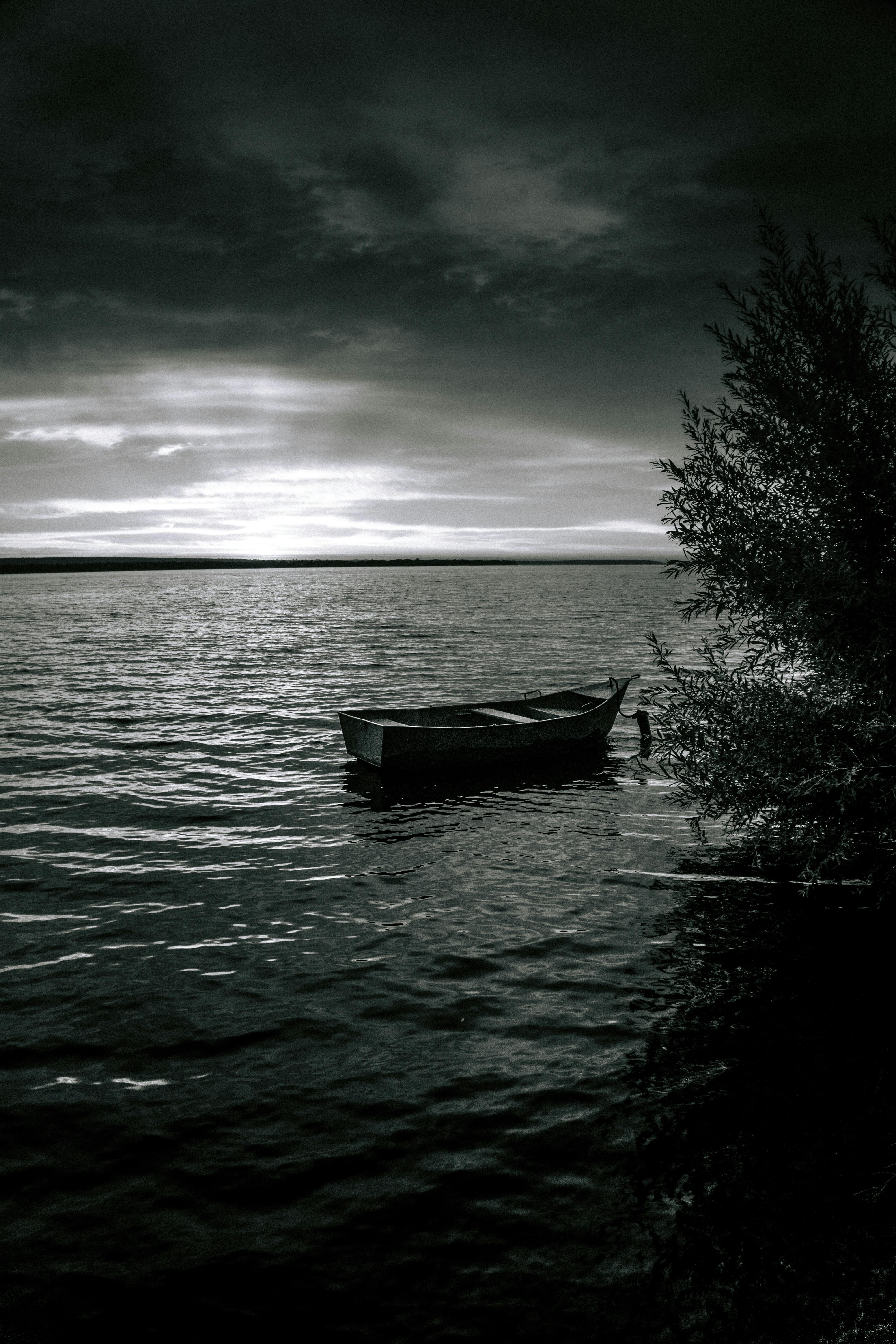 Grayscale Photo of a Boat on a Sea · Free Stock Photo
