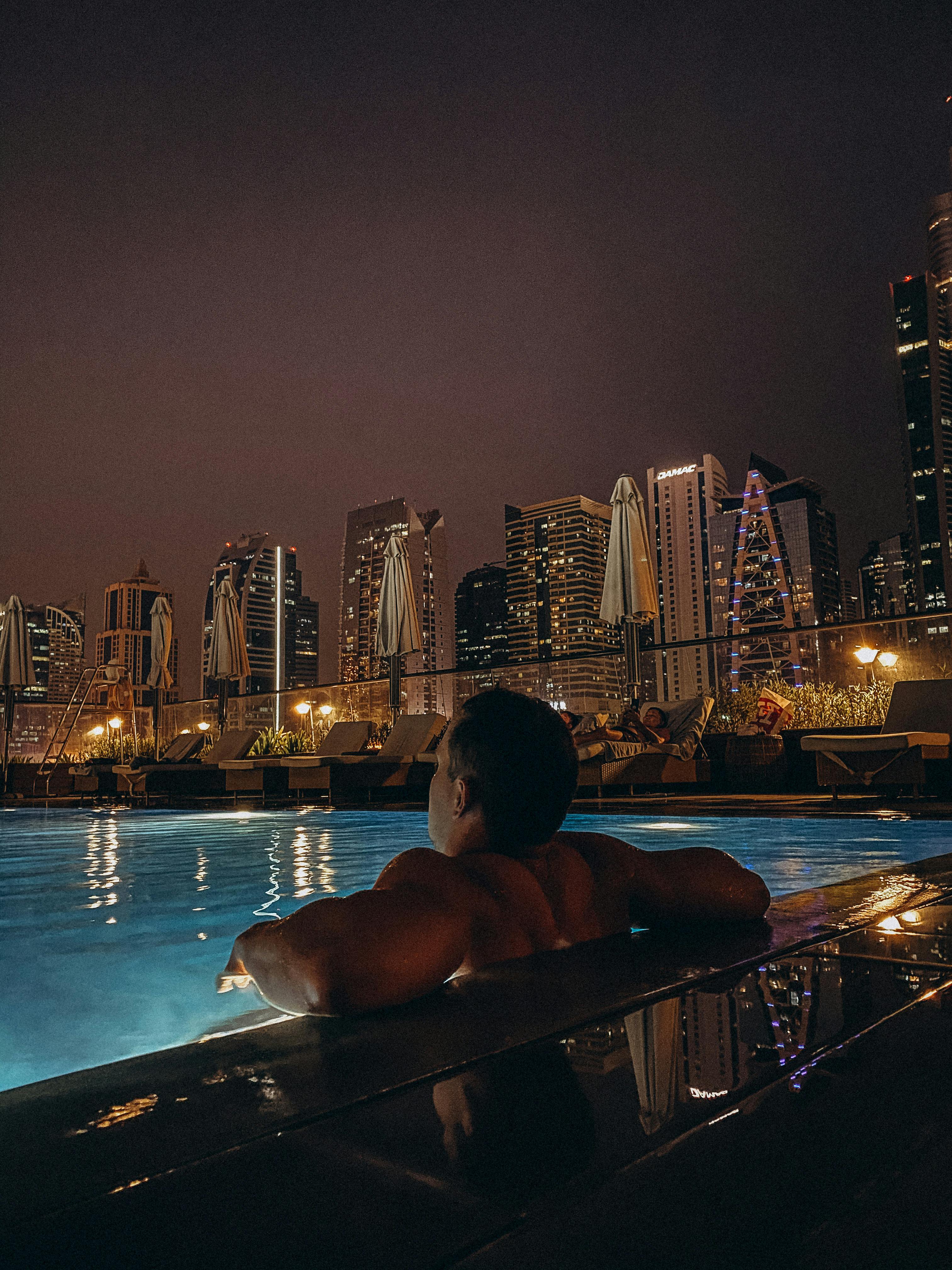 A Man in a Swimming Pool during Night Time · Free Stock Photo