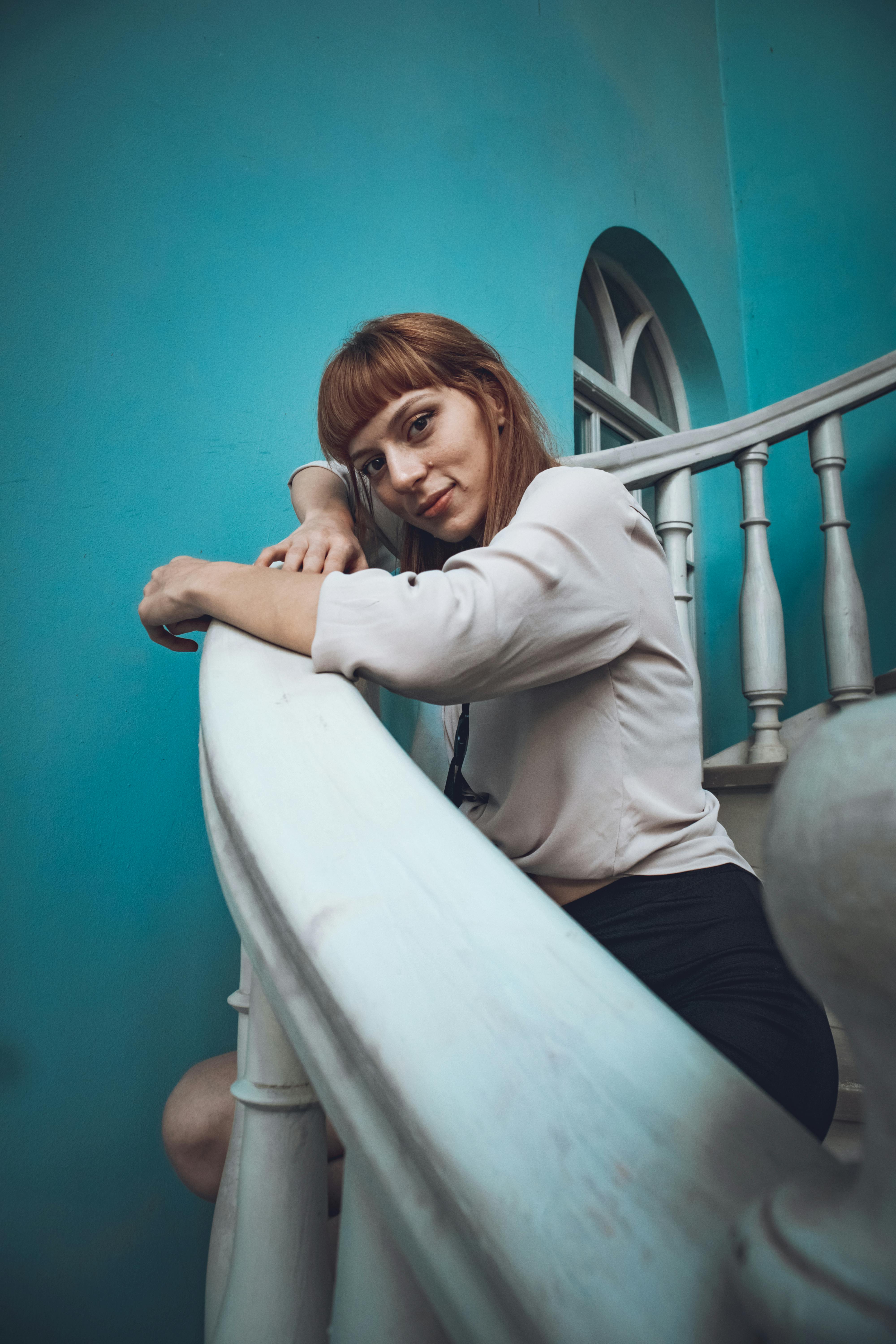 Woman Leaning Against Staircase Railing · Free Stock Photo