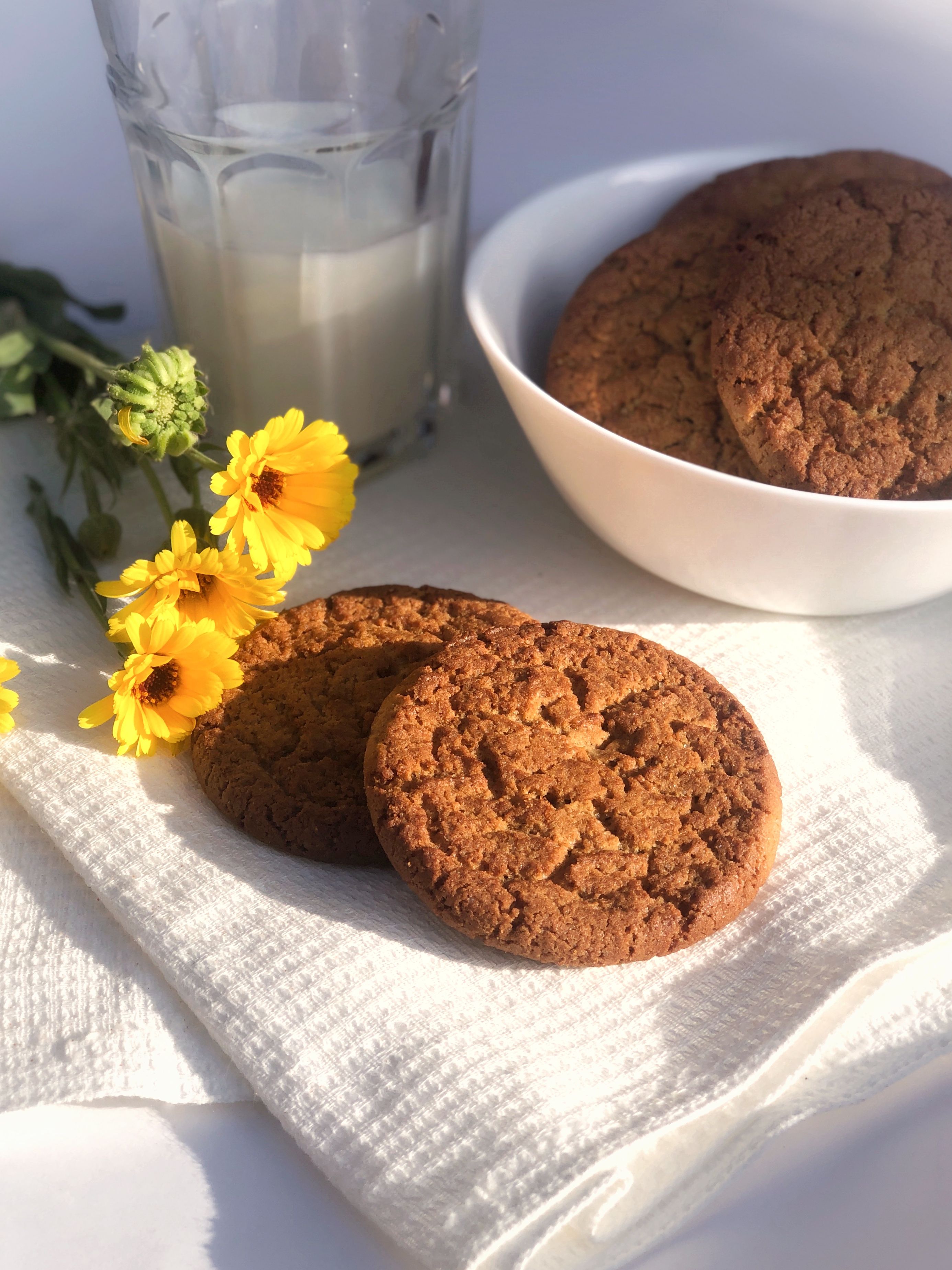 Brown Cookies Beside Bunch of Beautiful Yellow Flowers and a Glass of ...