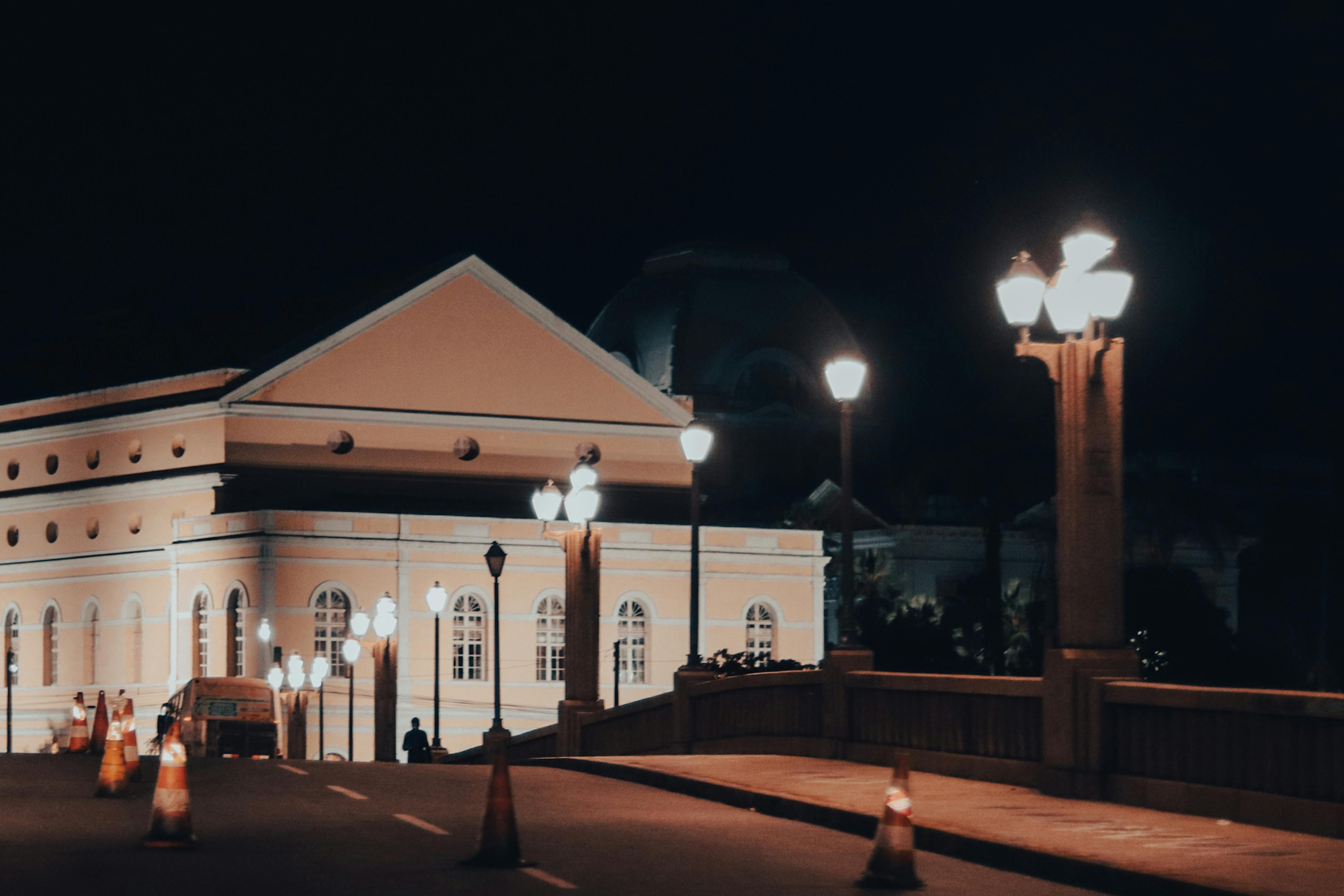 Light Posts Near Building During Night Time · Free Stock Photo