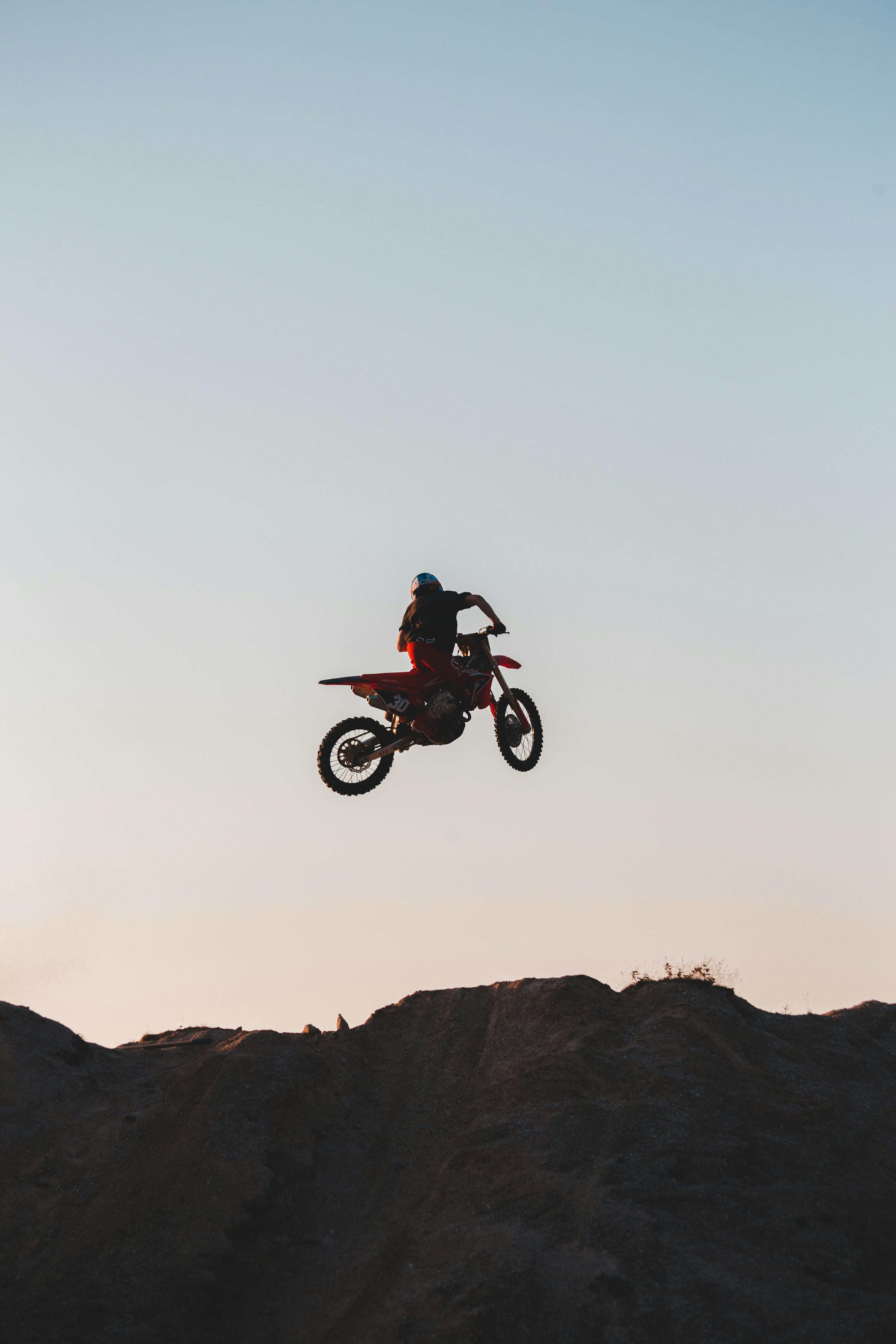 A Person on a Motorcycle above a Hill · Free Stock Photo