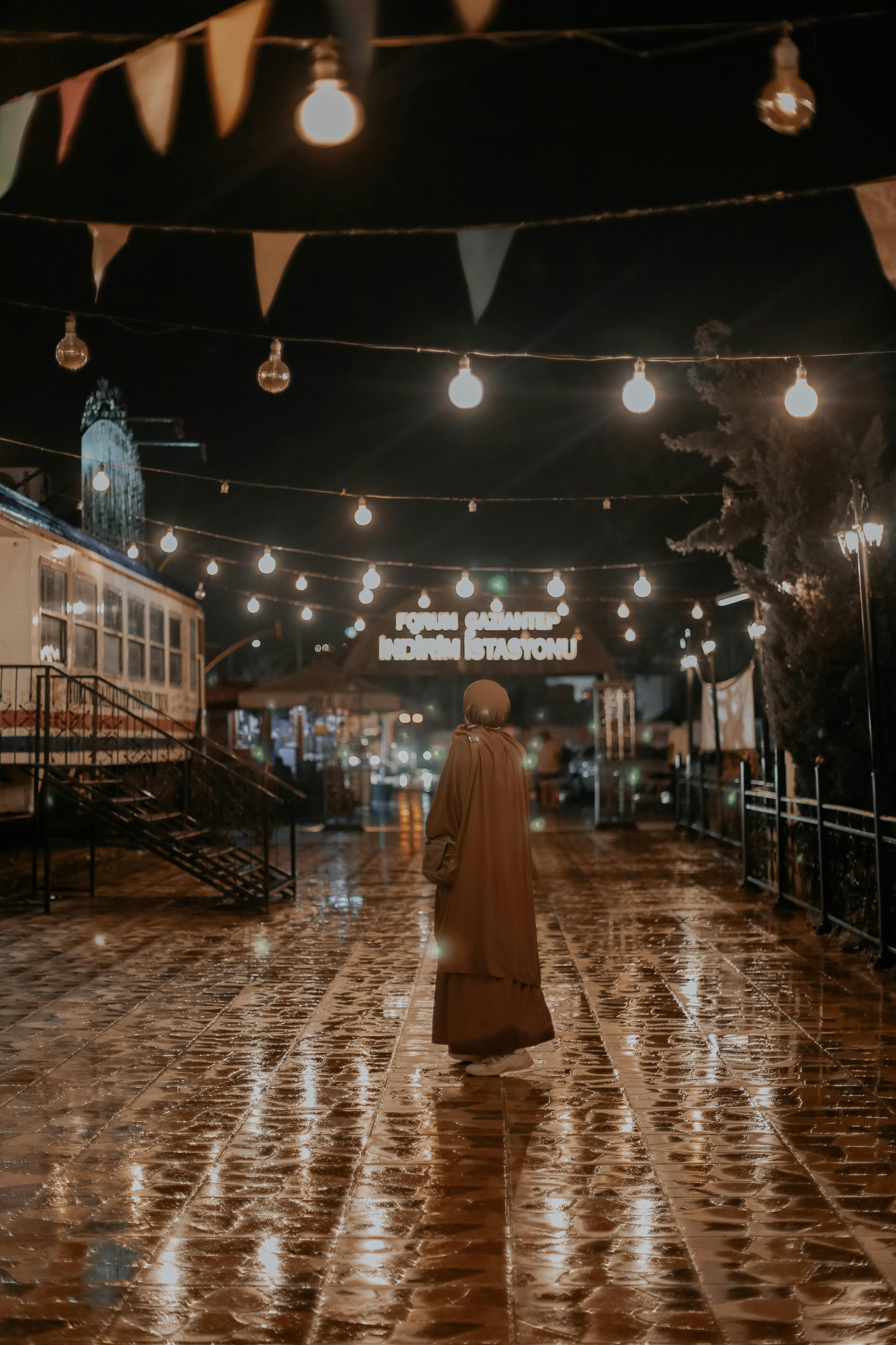 A Person Wearing Brown Abaya and Hijab Walking on a Wet Pavement · Free ...