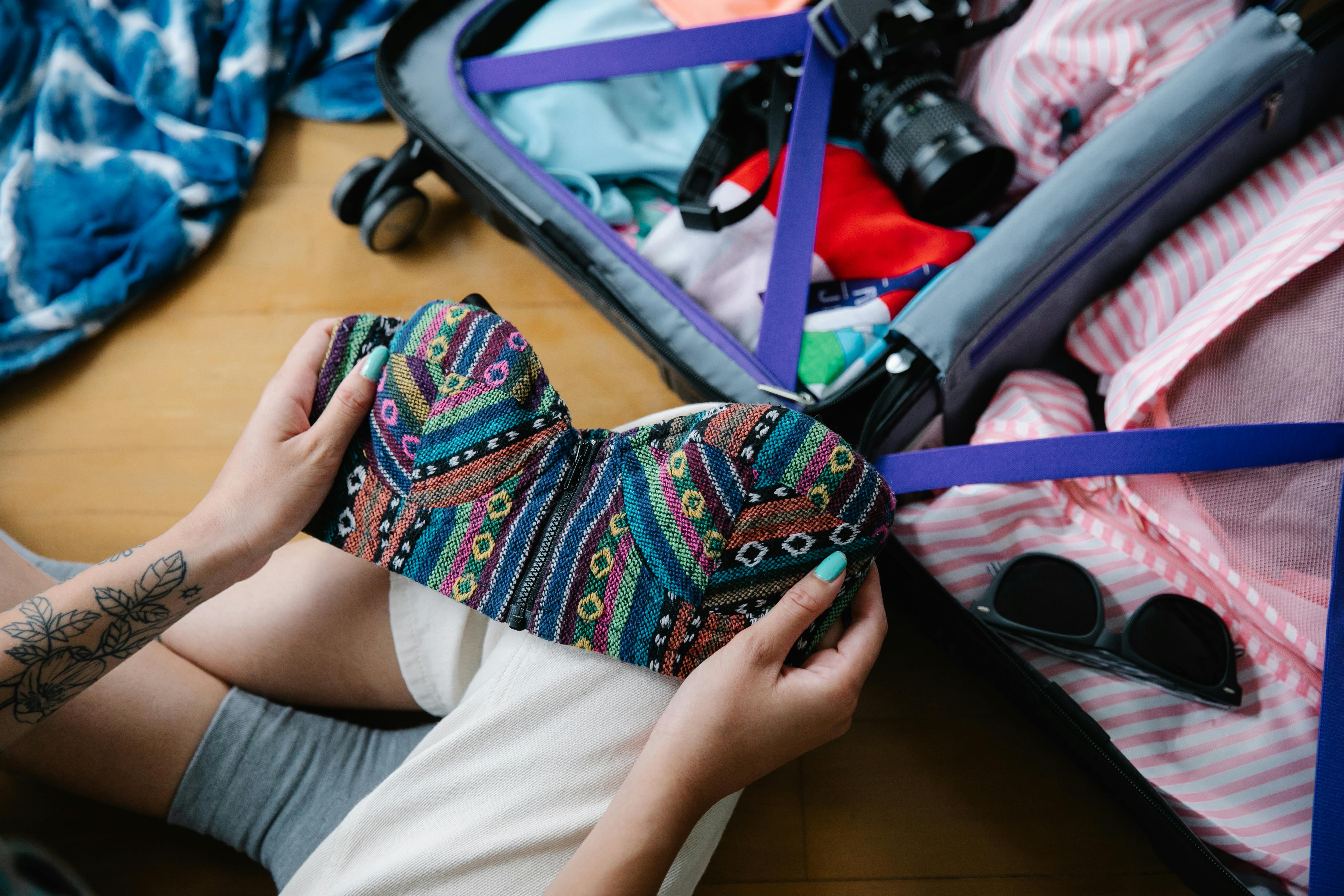 Unrecognizable Person Packing Clothes · Free Stock Photo