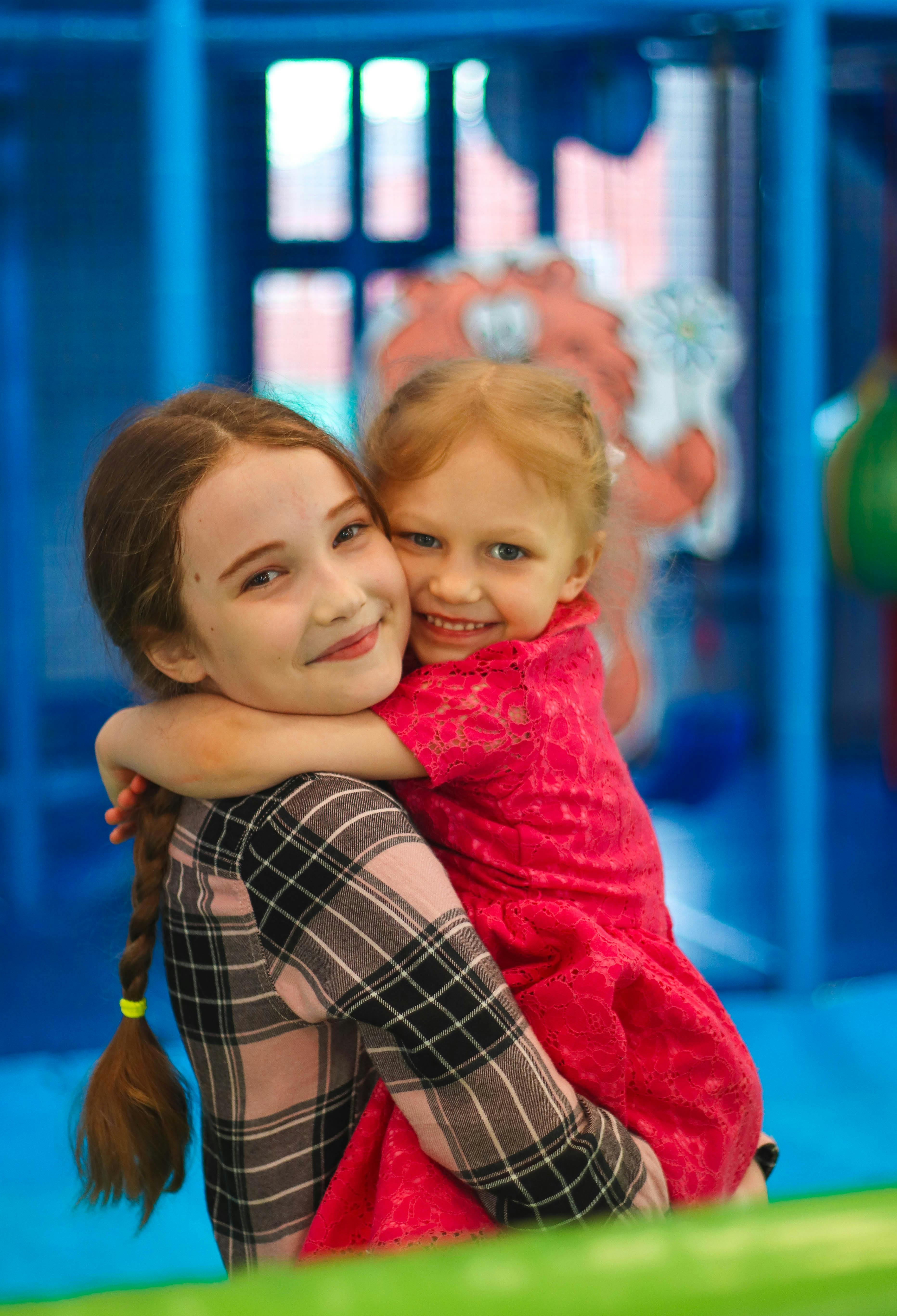A Girl Embracing her Younger Sister · Free Stock Photo