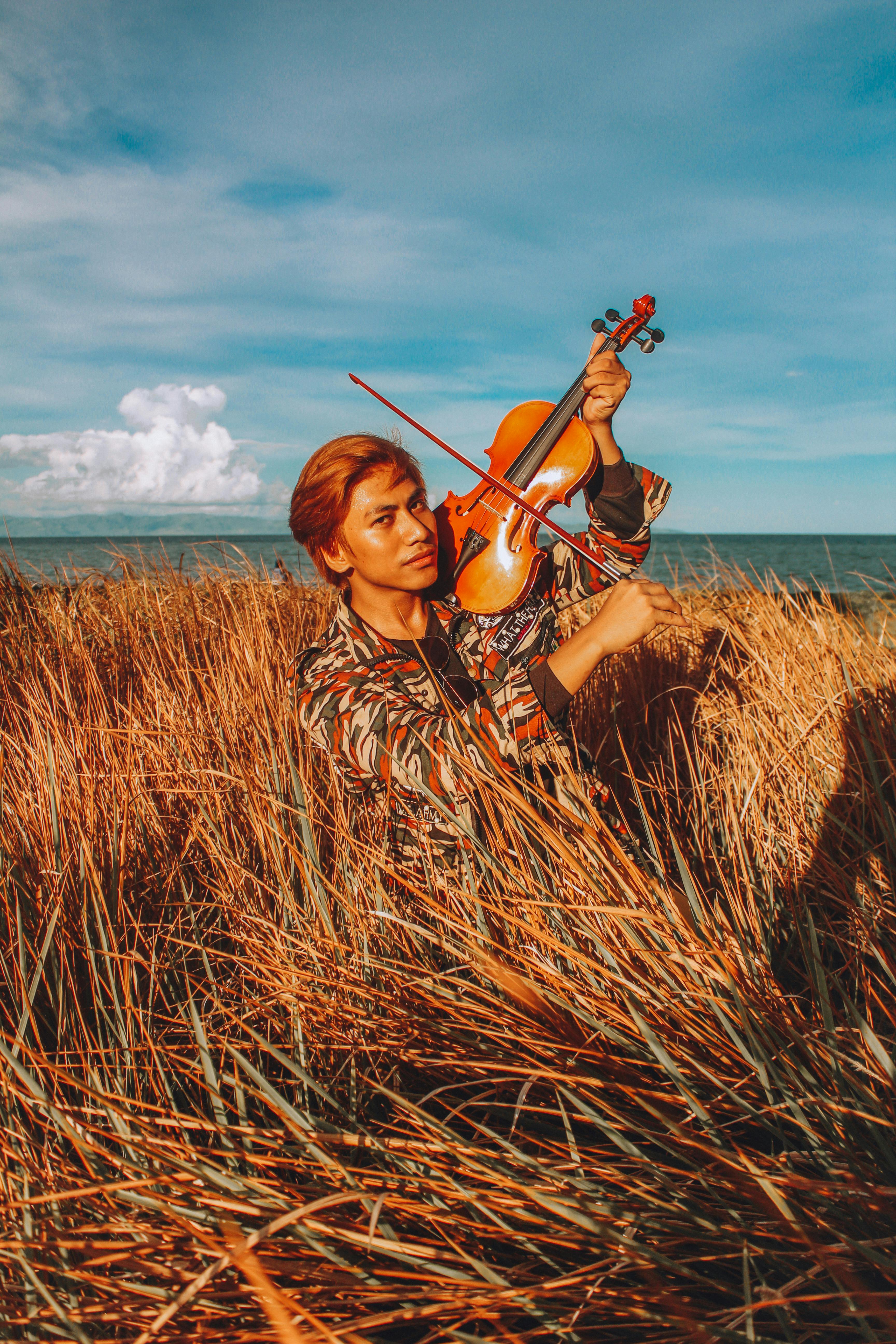 Man Pulling a Carpet with Women Sitting on It on a Field · Free Stock Photo
