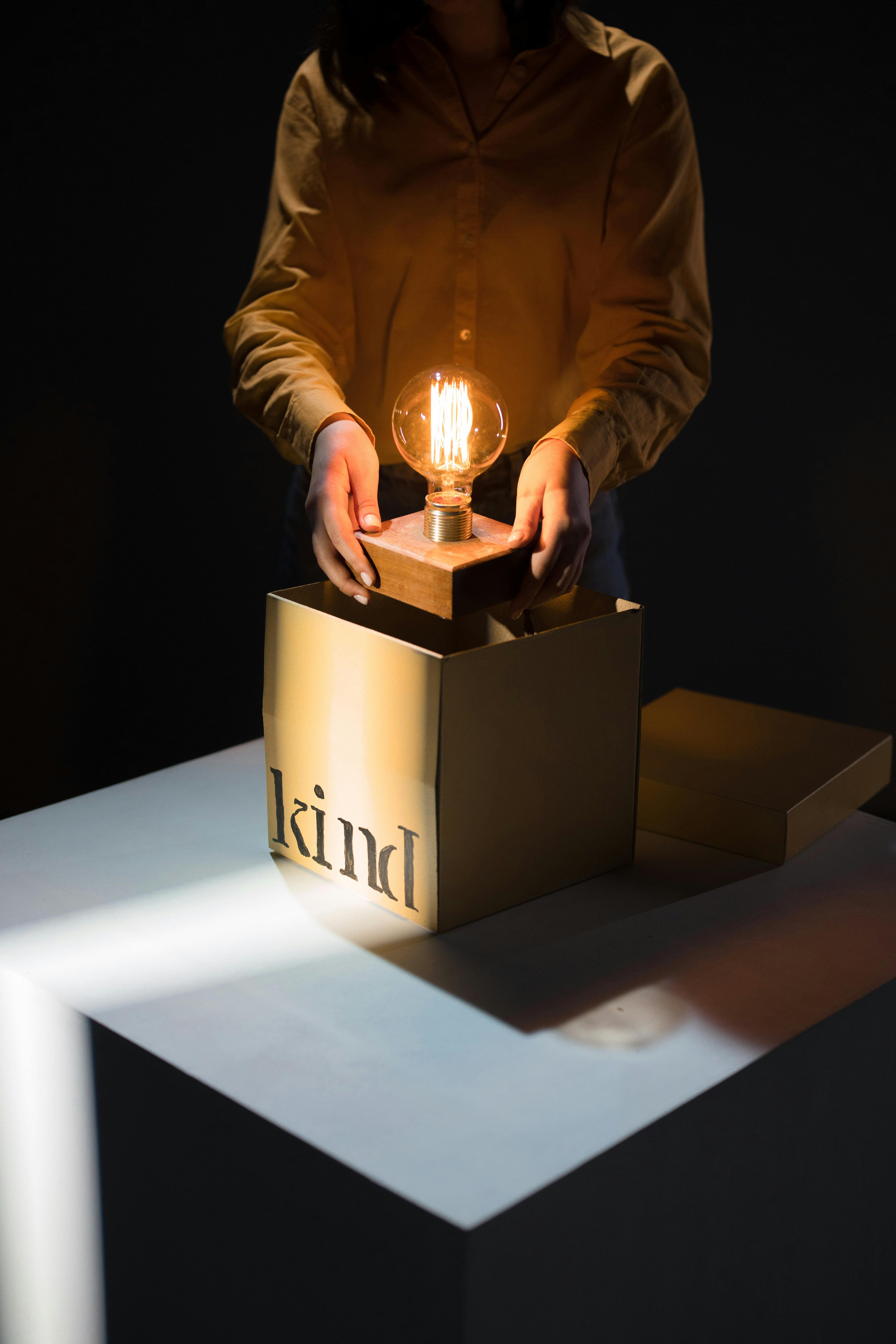 Woman holding a Lighted Light Bulb · Free Stock Photo