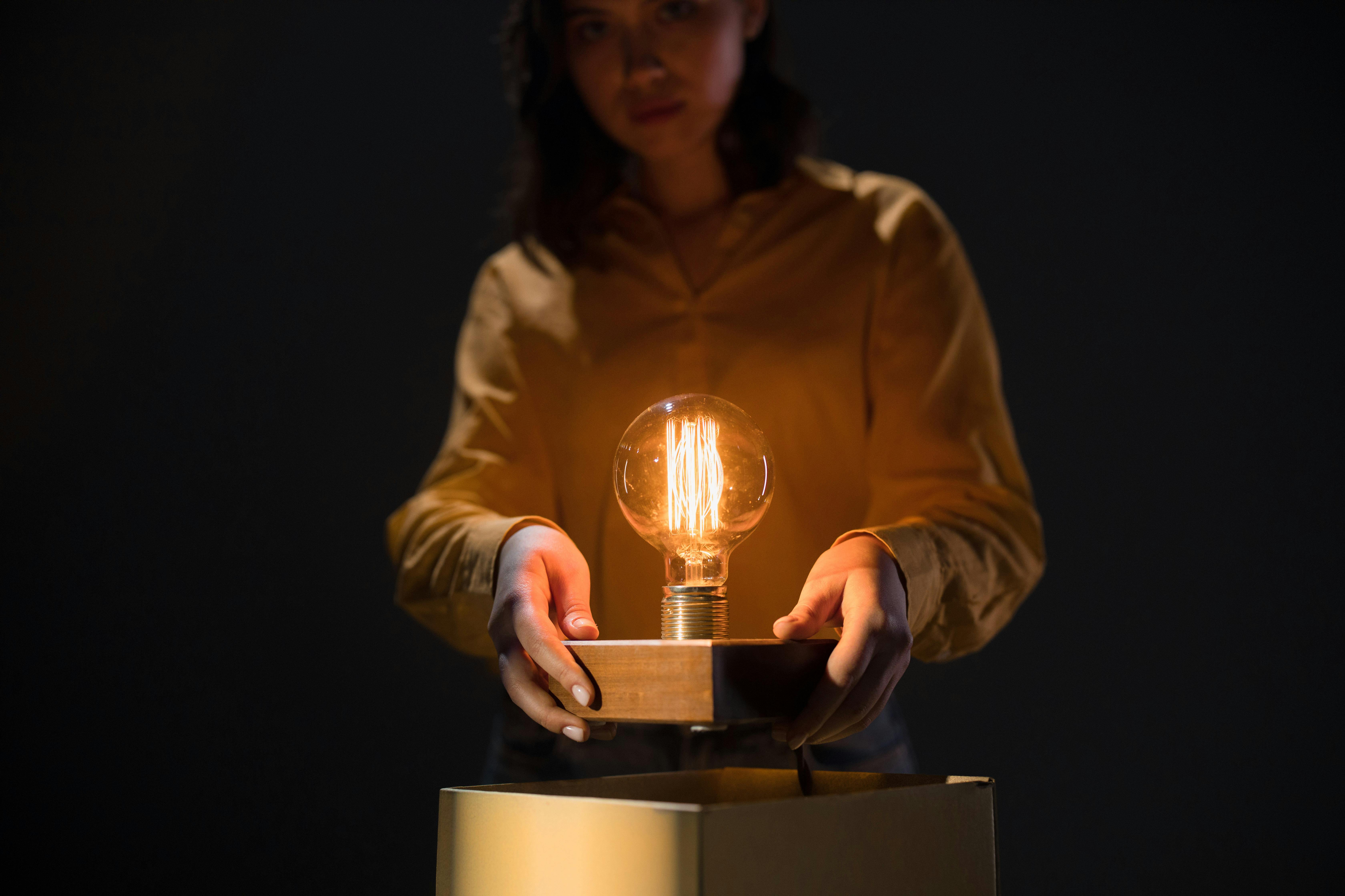 Woman Holding Light Bulb · Free Stock Photo
