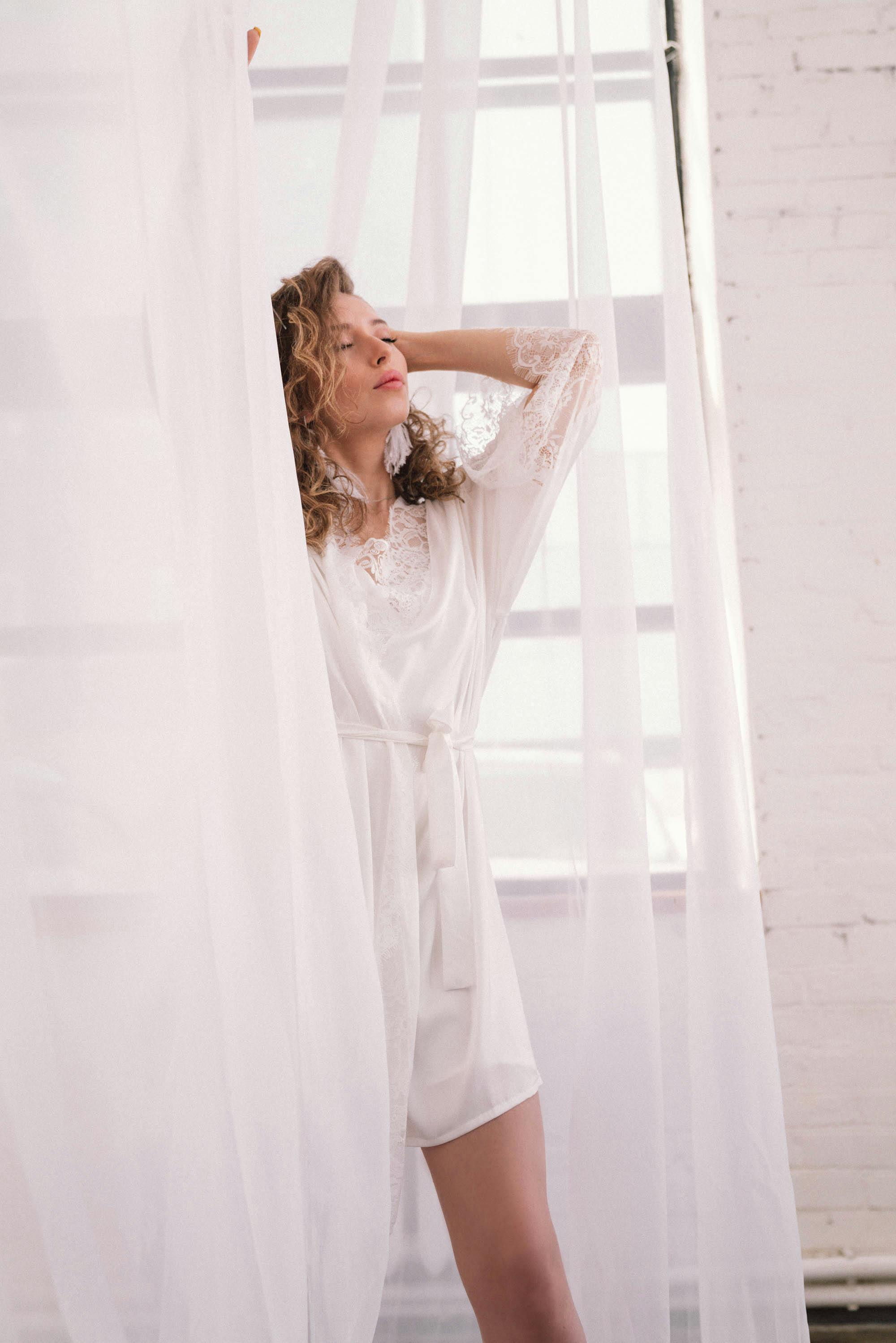A Woman in White Robe Standing Beside Sheer Curtain · Free Stock Photo