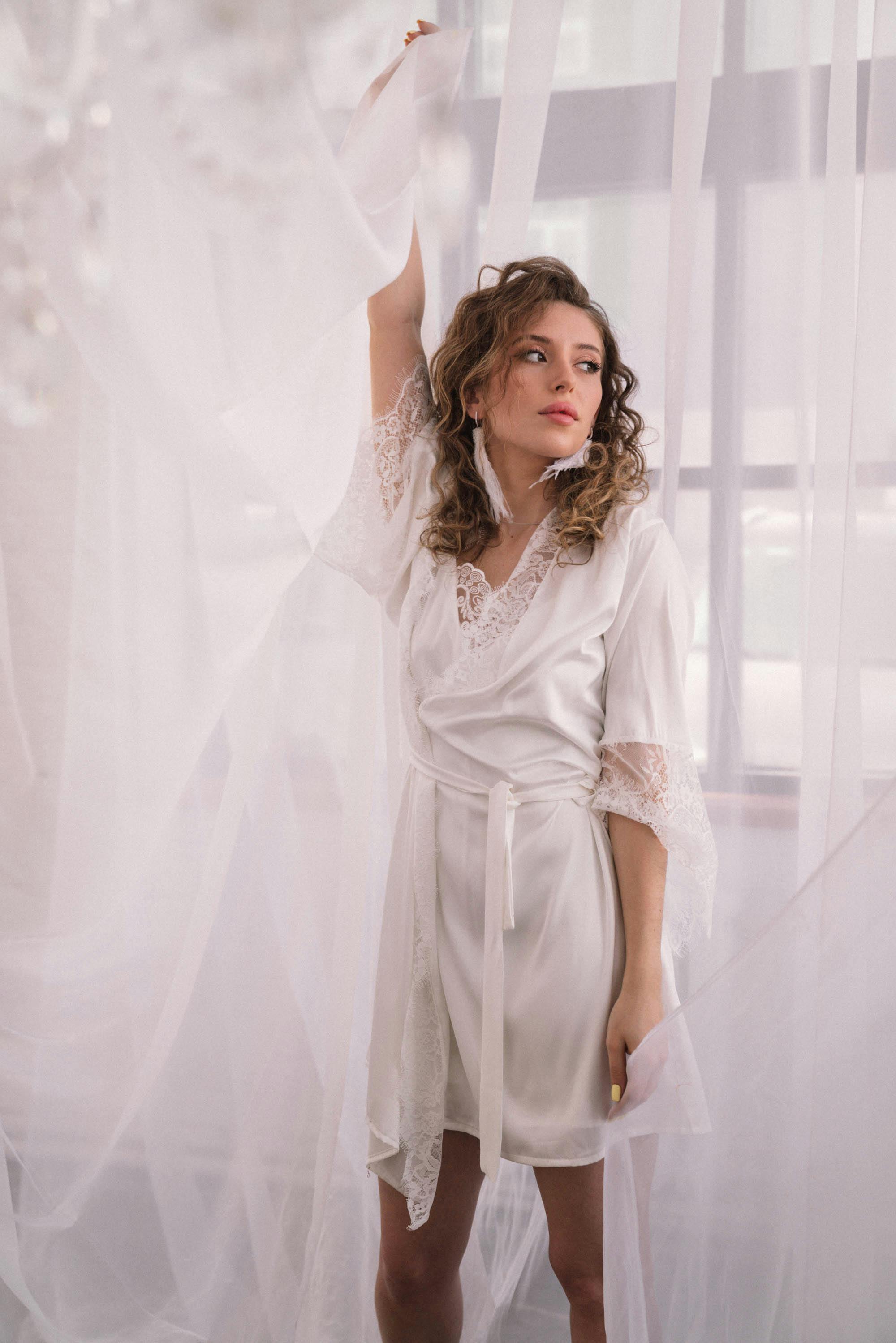 A Woman in White Robe Standing Beside Sheer Curtain · Free Stock Photo