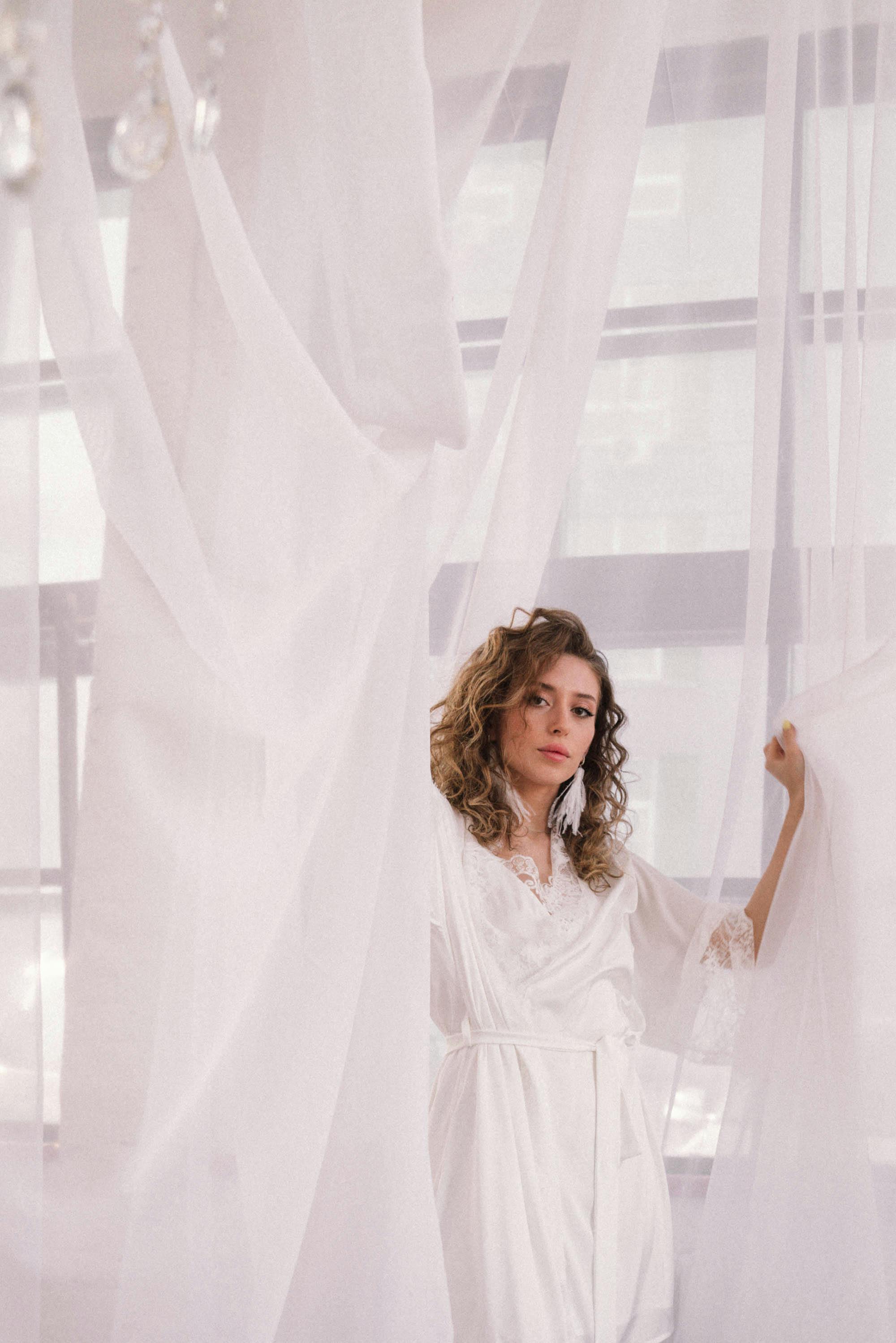 Woman in White Silk Robe Standing Beside White Curtain · Free Stock Photo