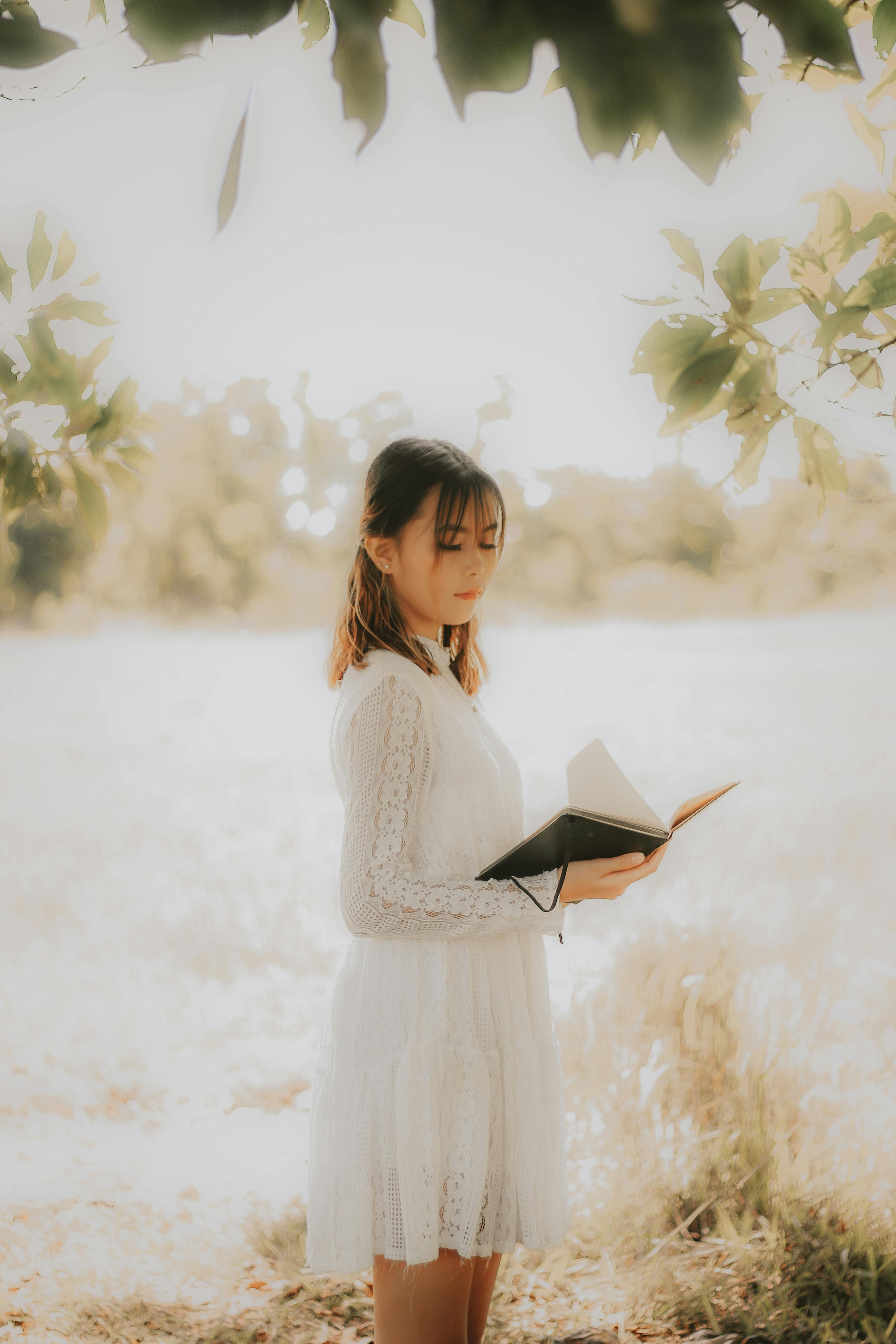 Woman in White Long Sleeve Dress Holding Book · Free Stock Photo