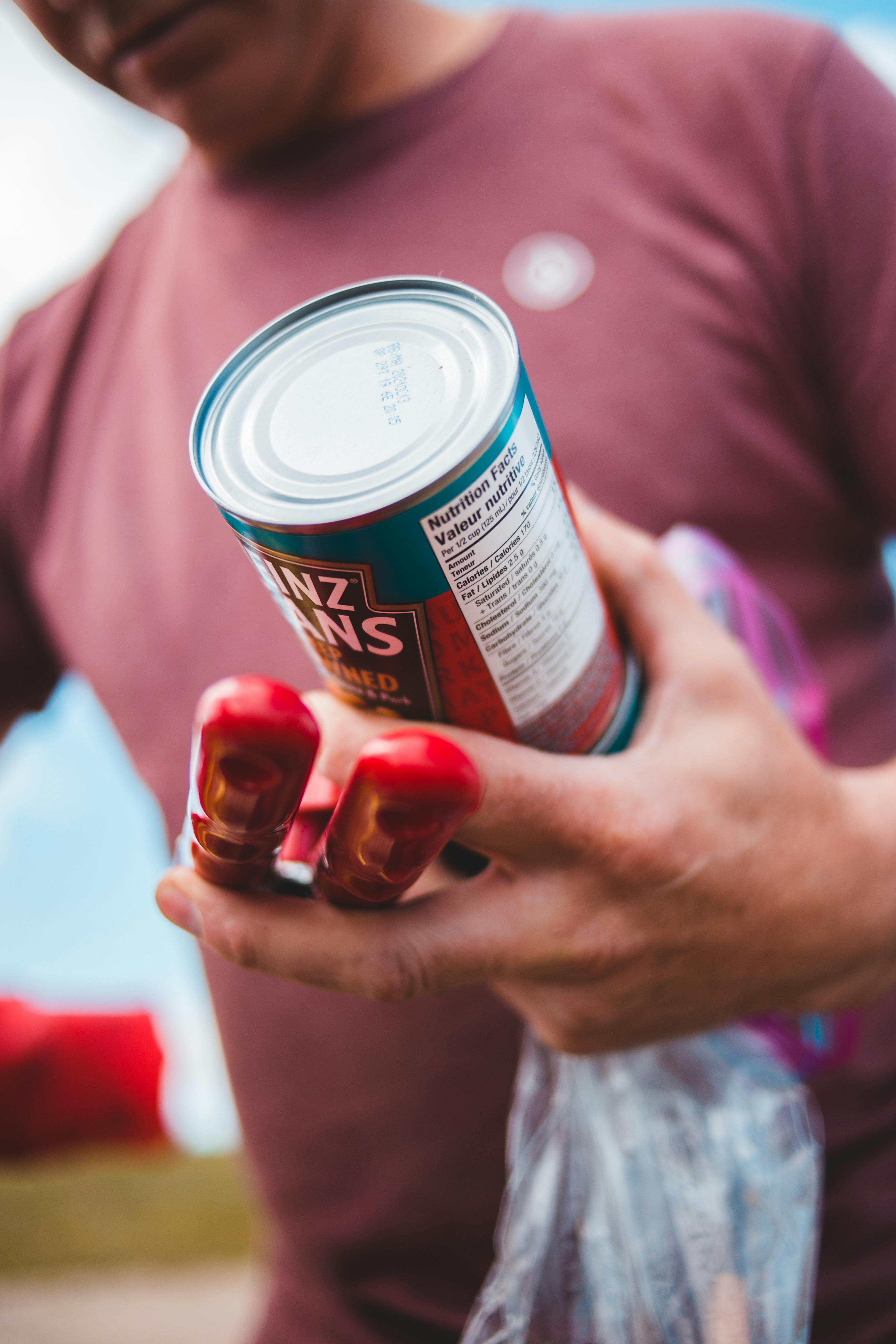Person Holding a Labeled Can · Free Stock Photo