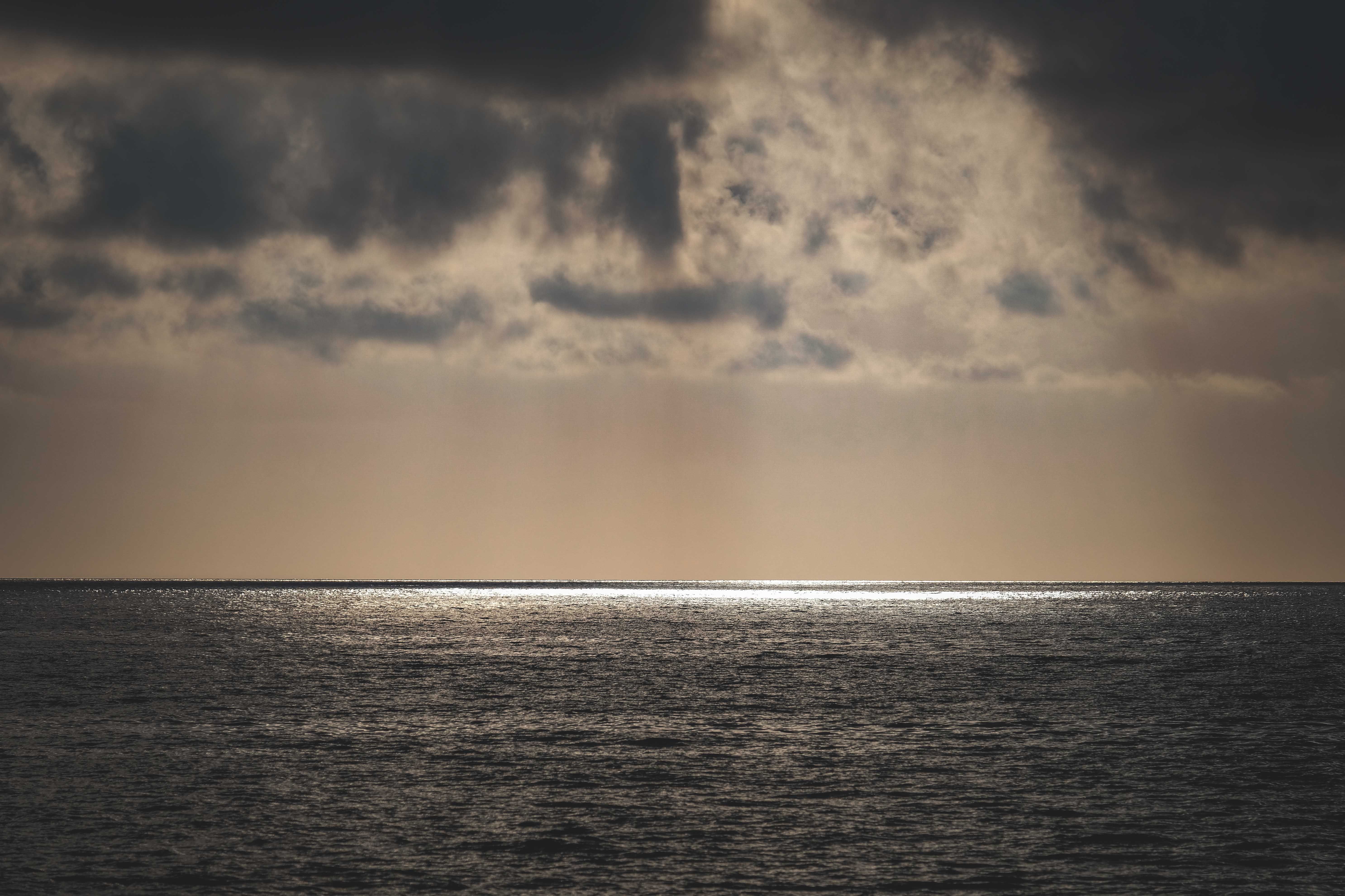A Calm Ocean Under Gray Clouds · Free Stock Photo