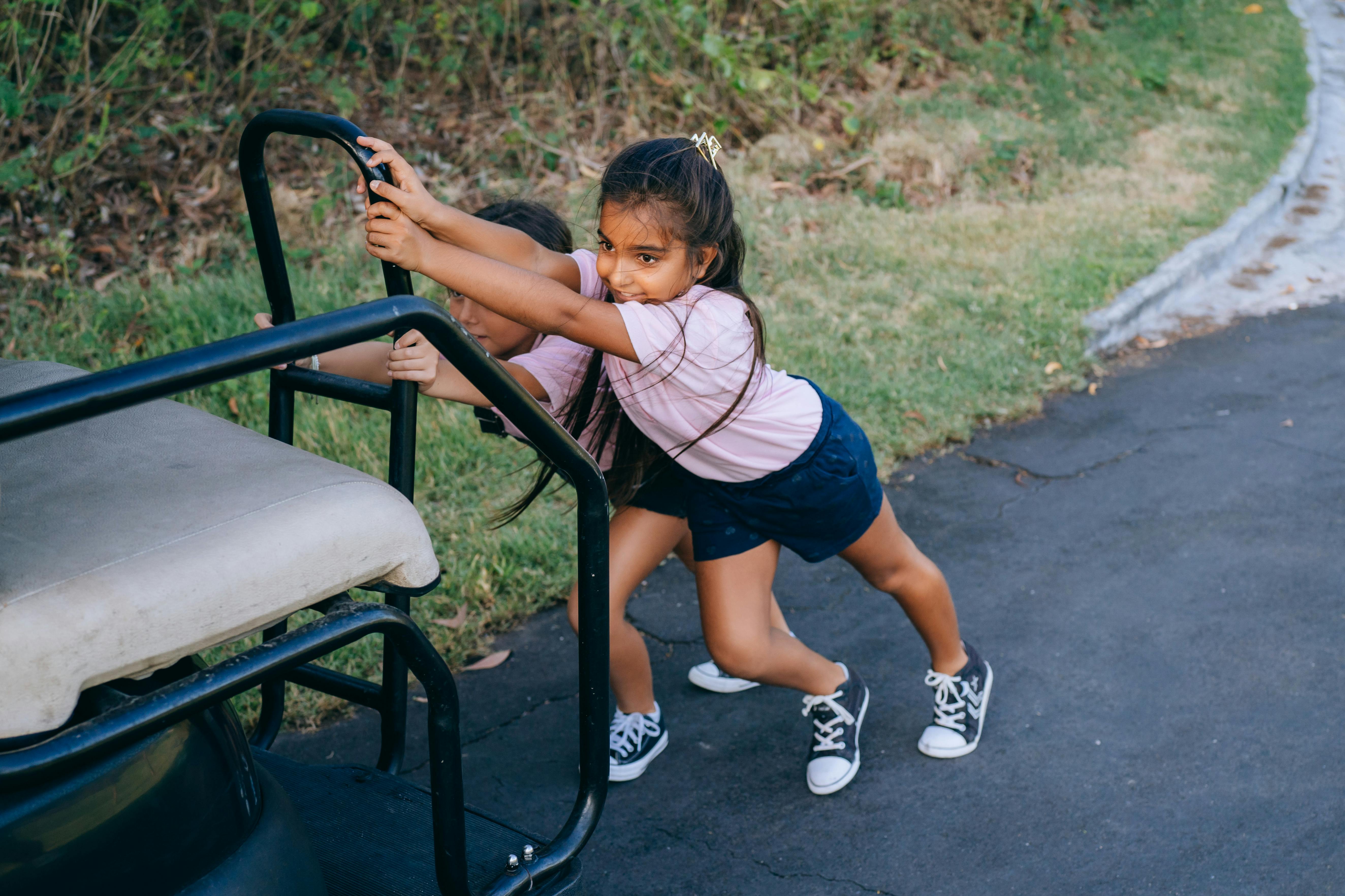 Girls pushing a Golf Cart · Free Stock Photo