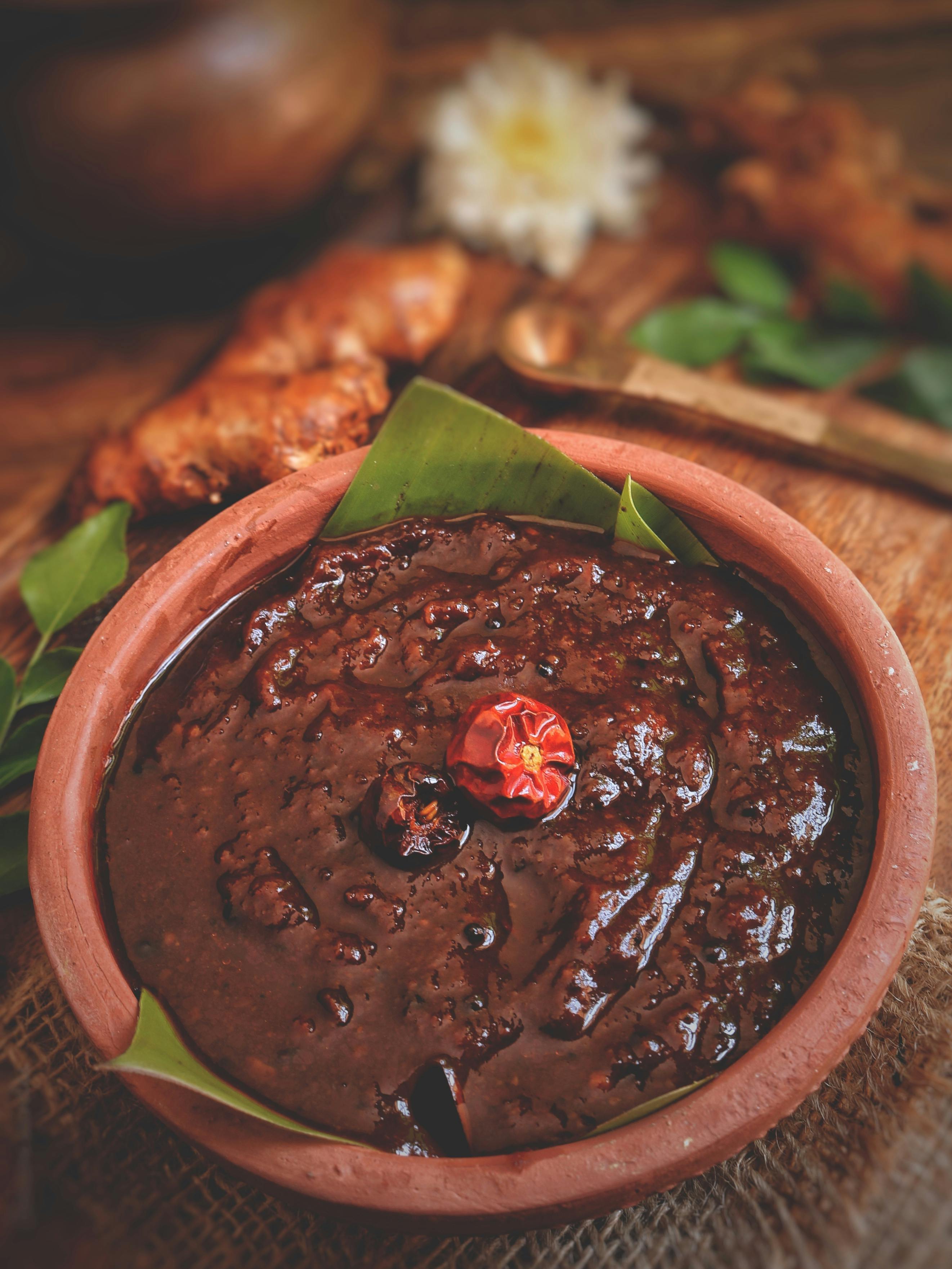 A Red Round Fruit on Dark Sauced Food · Free Stock Photo