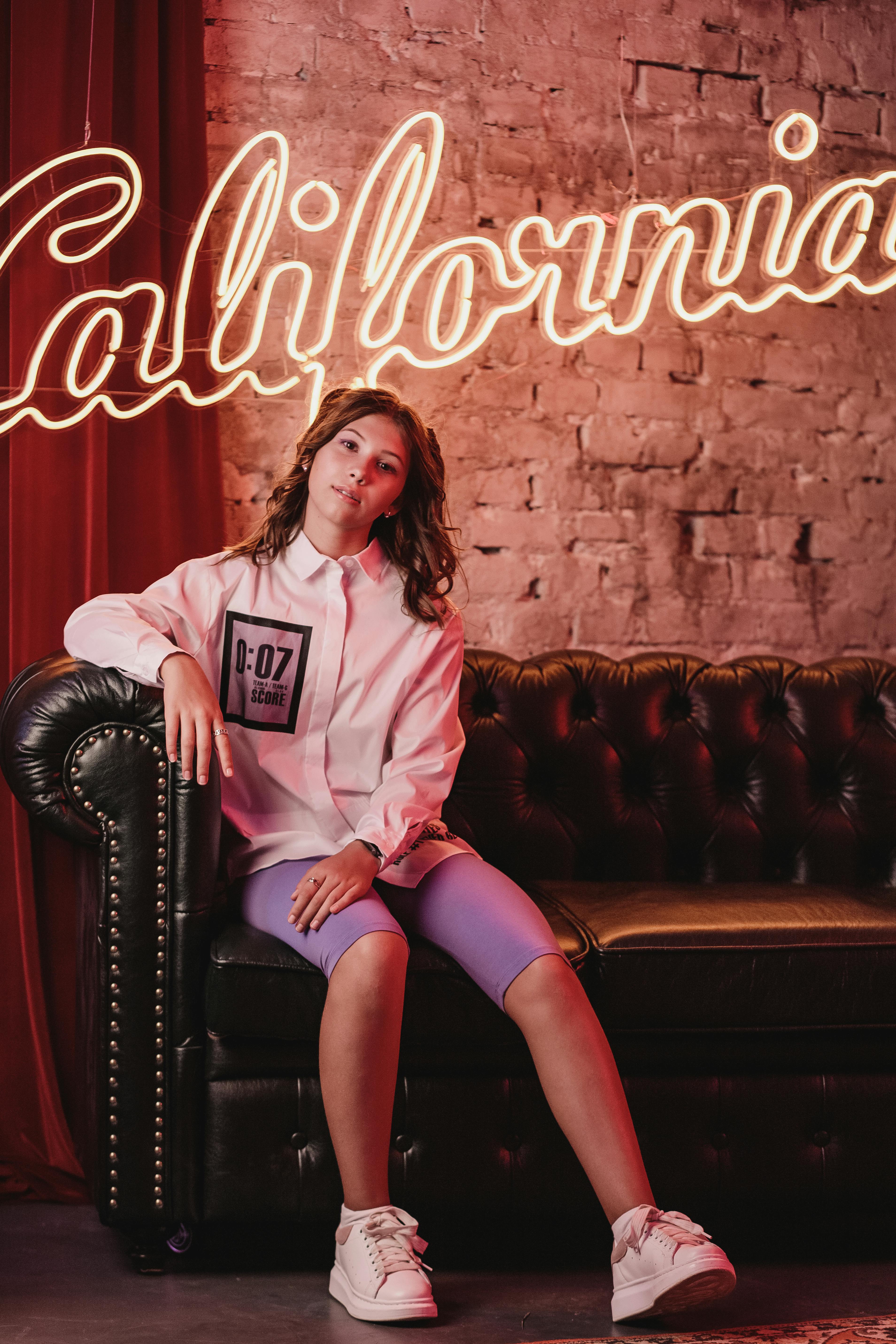 A Woman Sitting on the Leather Sofa · Free Stock Photo