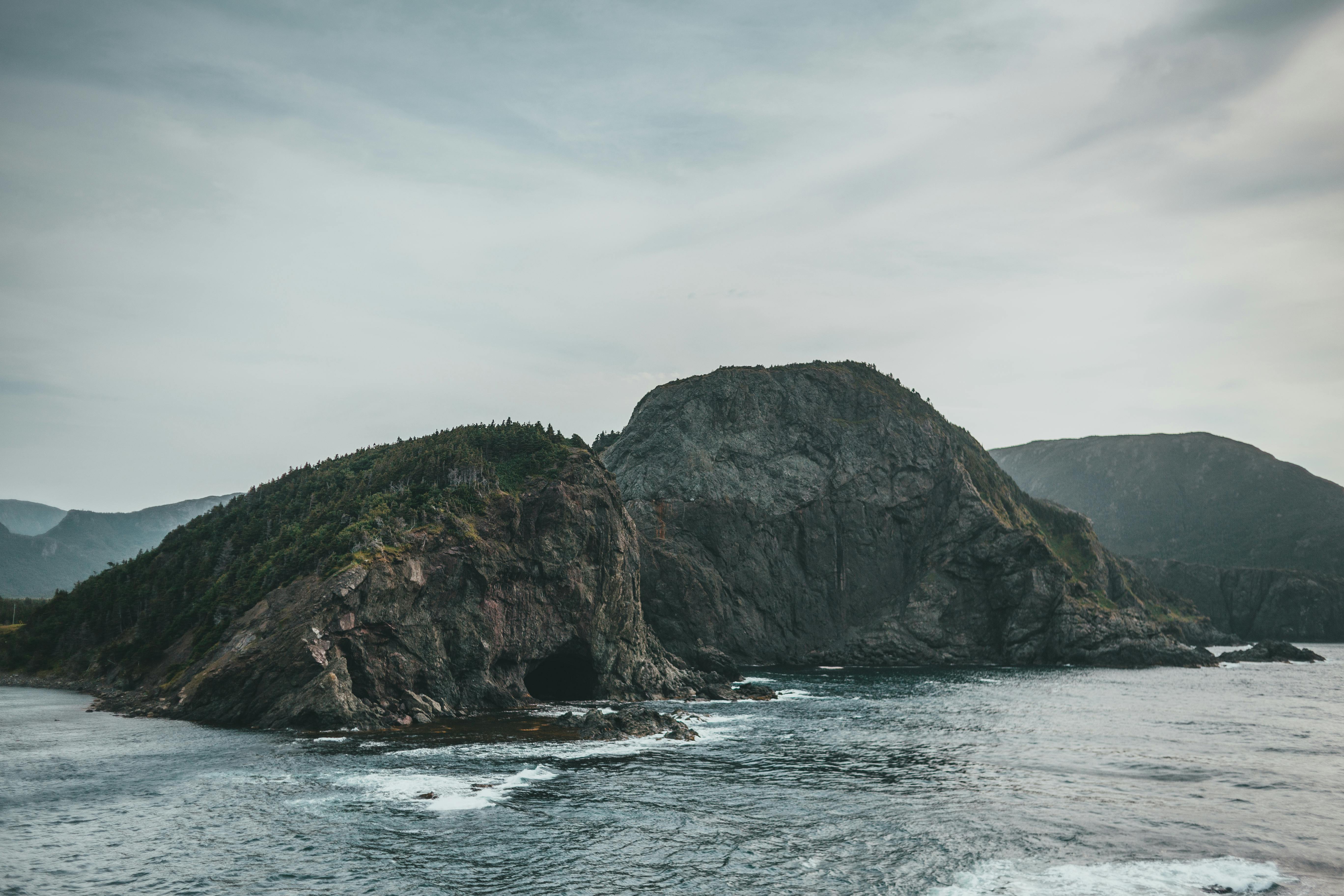 Gray Rock Formation on Sea Under White Clouds · Free Stock Photo