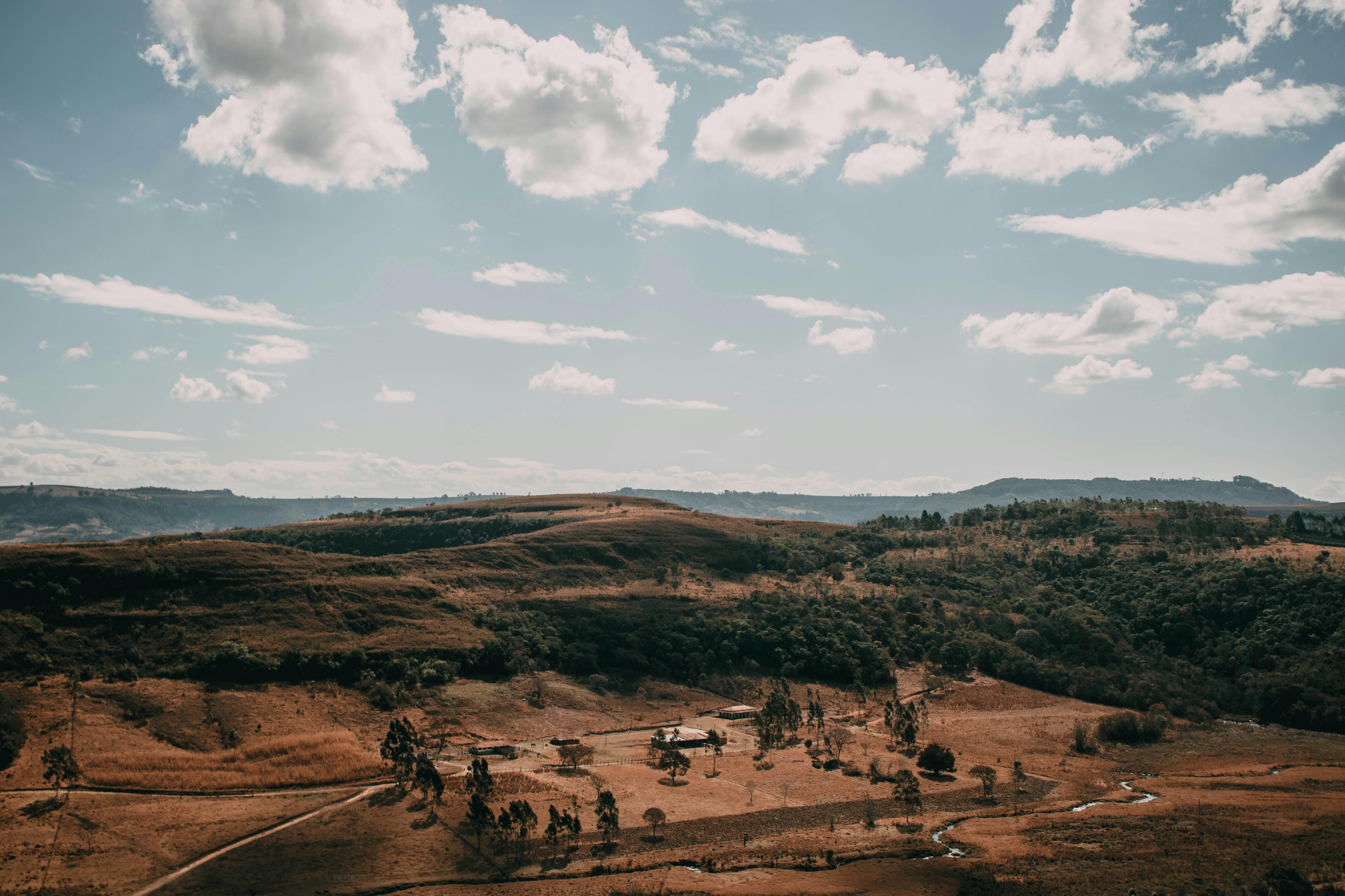 Green Trees on Brown Fields Near Mountain Ranges · Free Stock Photo