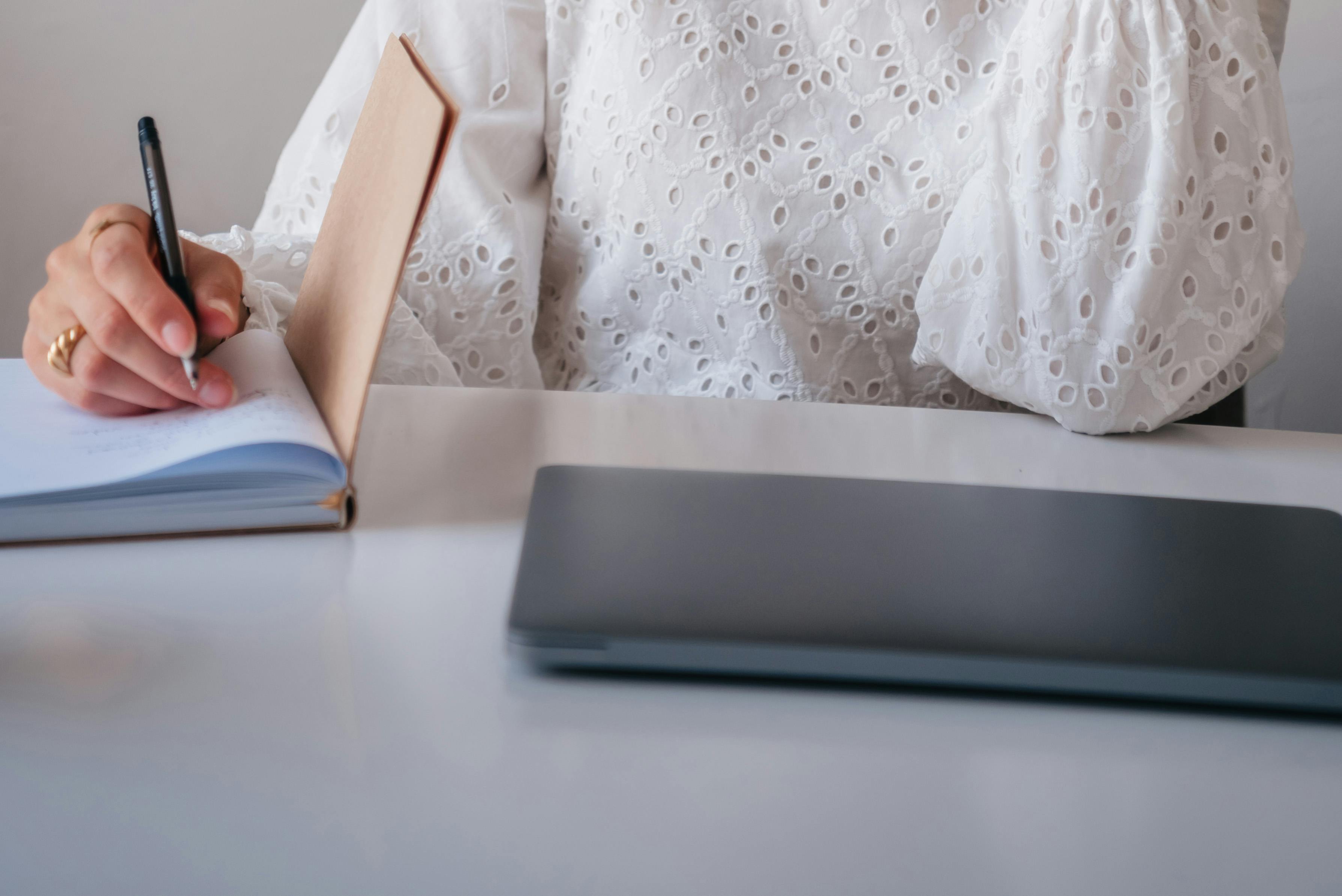 Close Up Photo of Person Holding Notebook and a Pen · Free Stock Photo