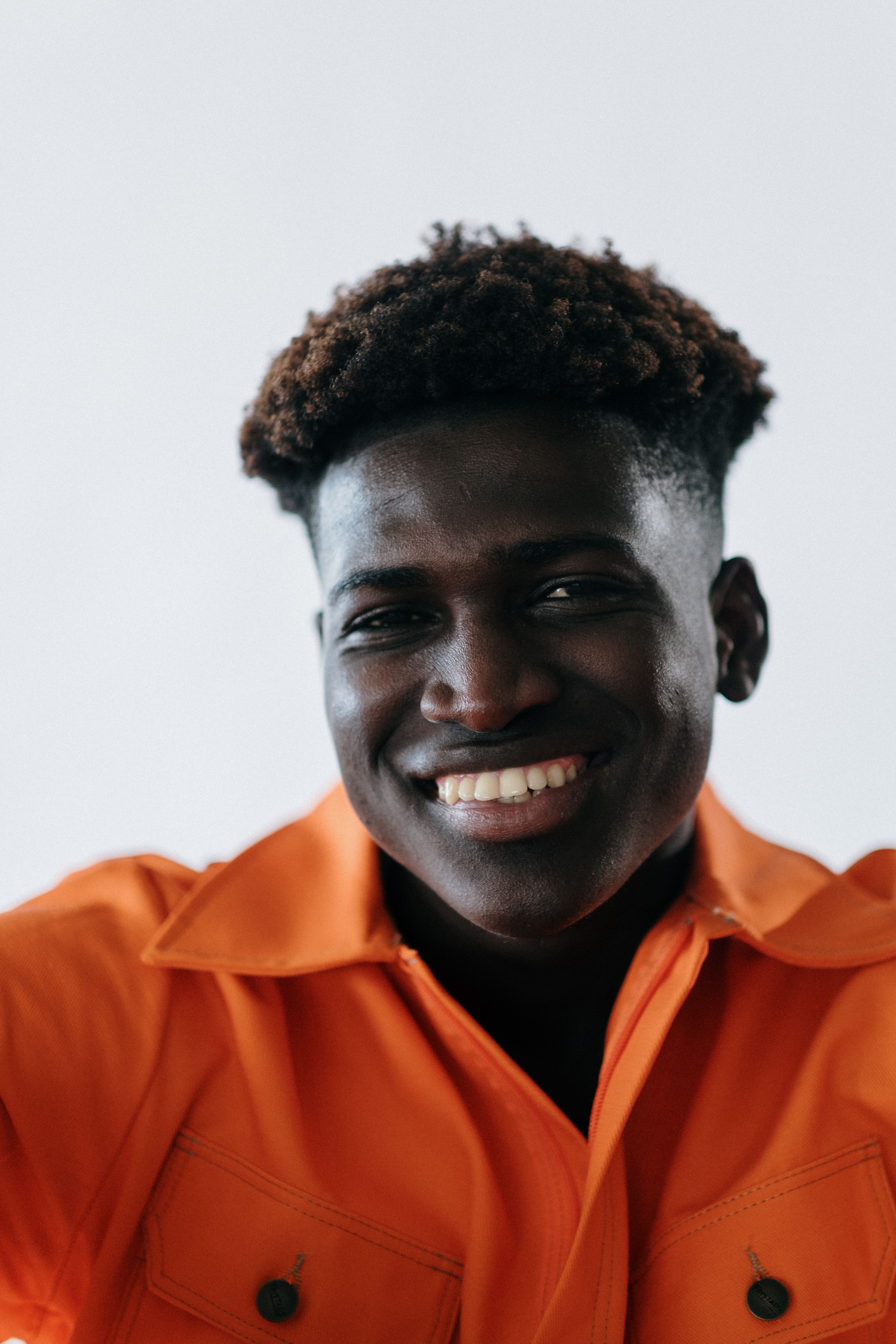 A Man Smiling Wearing Orange Polo · Free Stock Photo