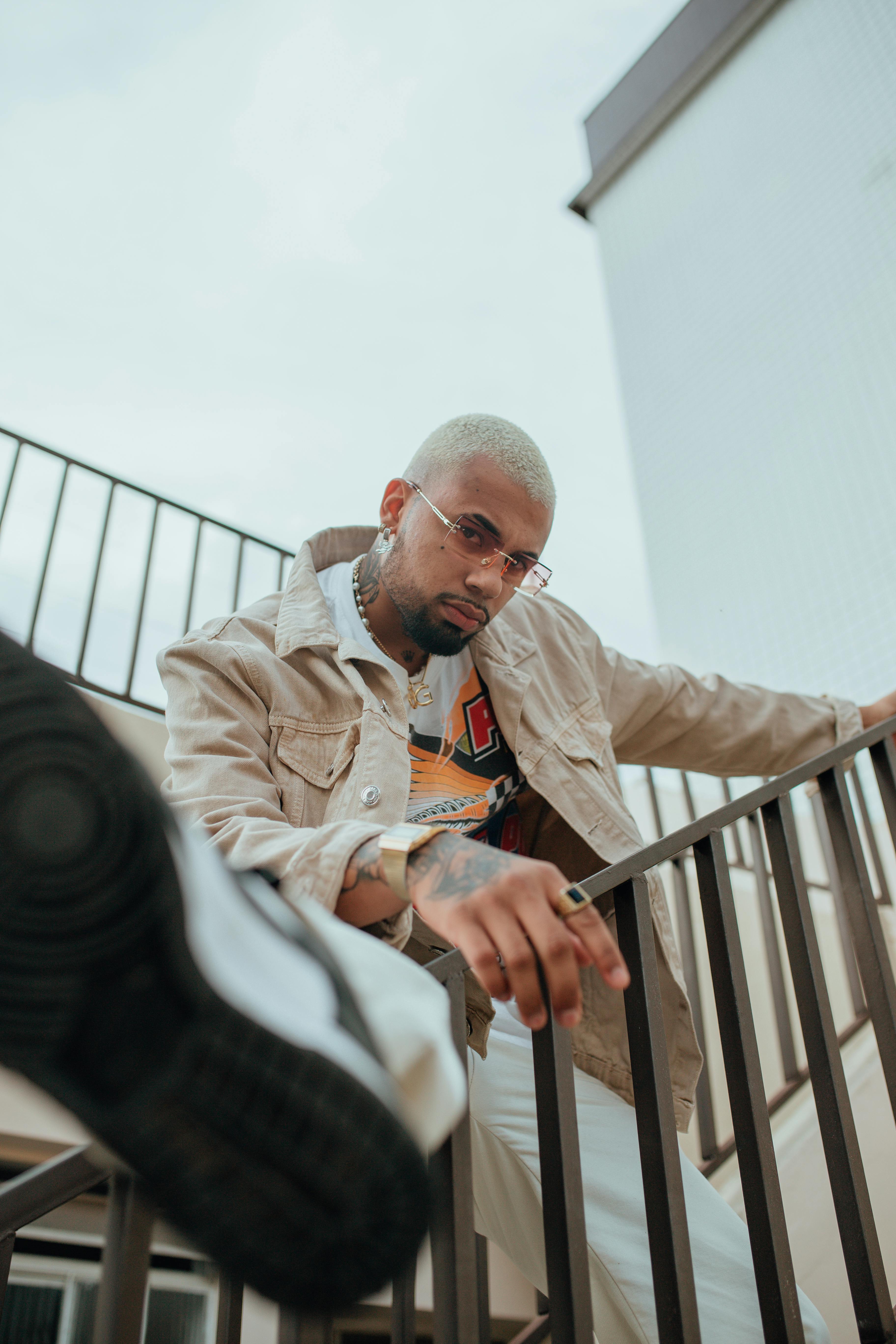 Man in Beige Jacket Standing beside Black Metal Railing · Free Stock Photo
