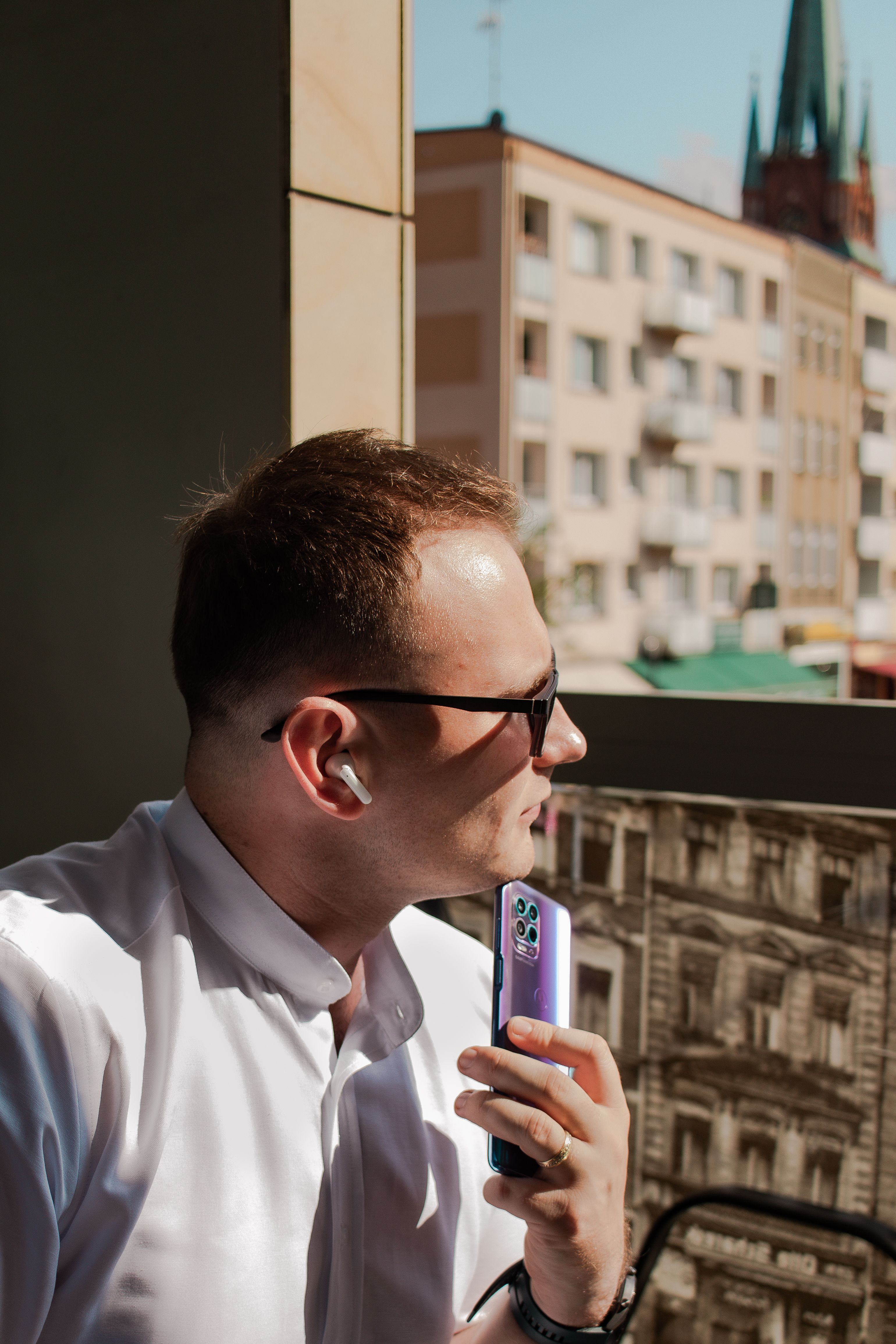 Thoughtful Indian man with earbuds browsing smartphone · Free Stock Photo