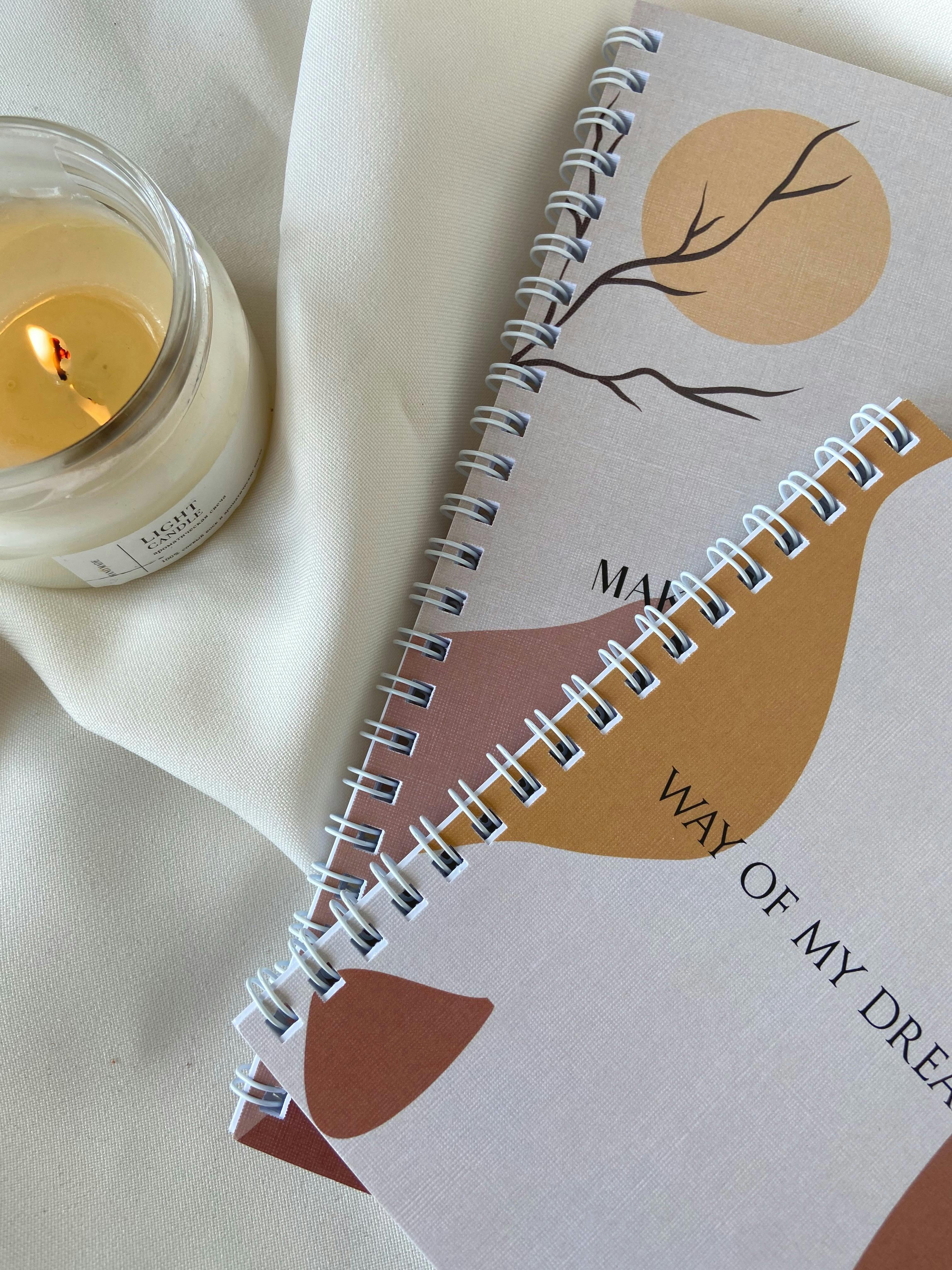 Spiral Notebooks and a Lighted Candle · Free Stock Photo