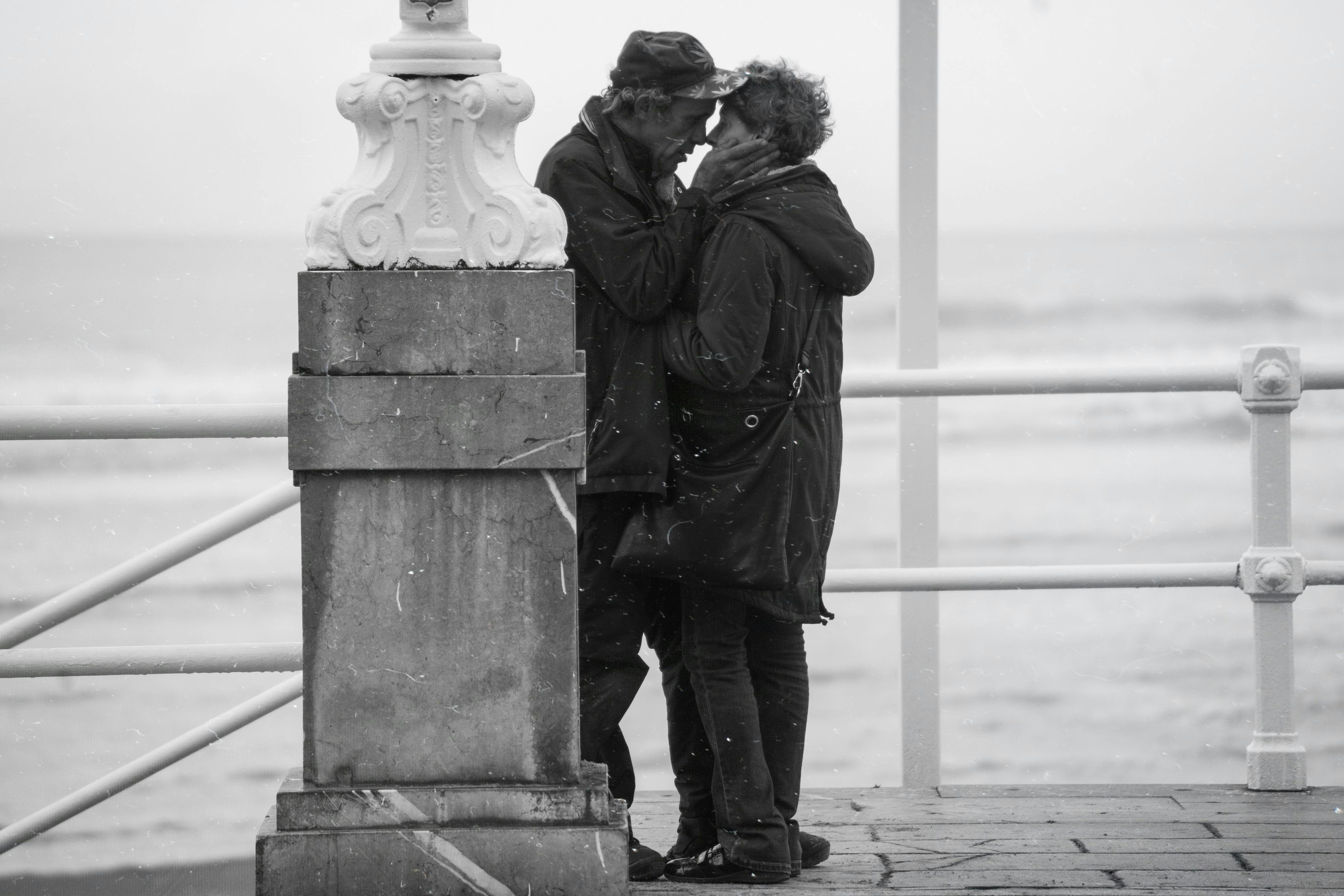 Man and Woman Standing Face to face Beside a Railing · Free Stock Photo