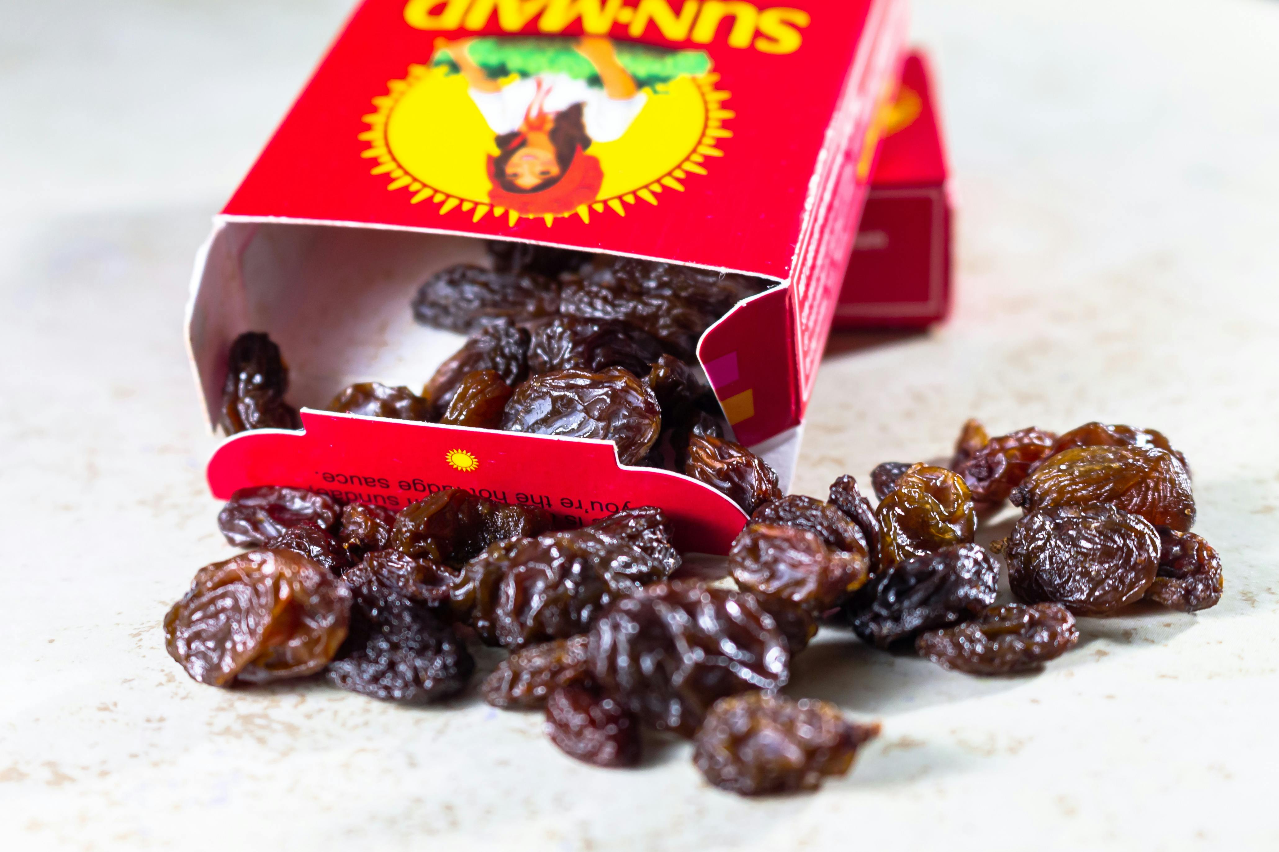 Spilled Raisin From the Box in Close-up Photography · Free Stock Photo
