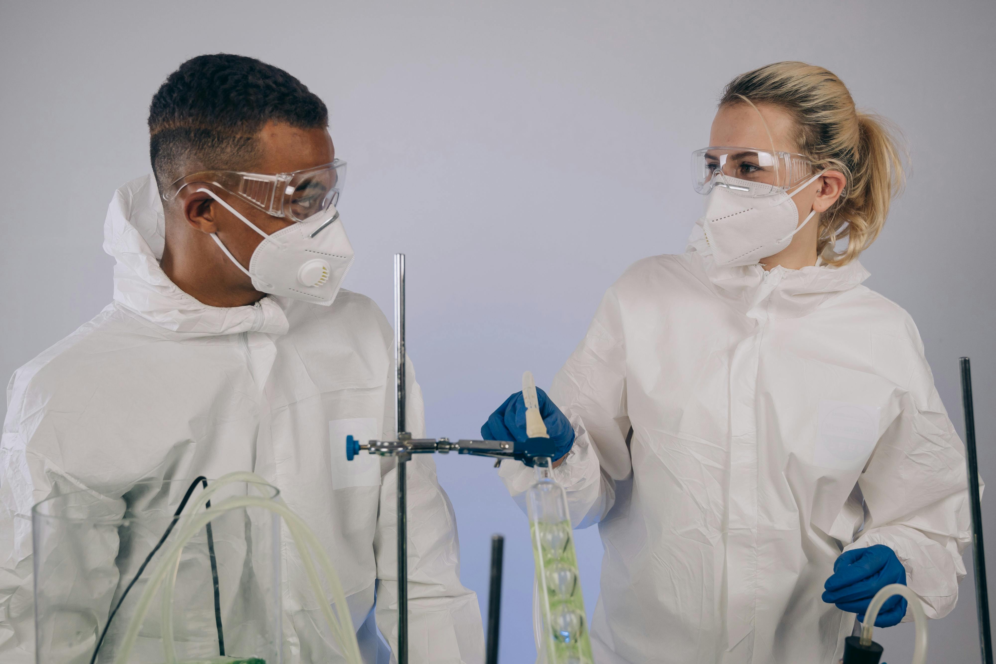 Chemists Wearing Facemasks Doing a Science Experiment · Free Stock Photo