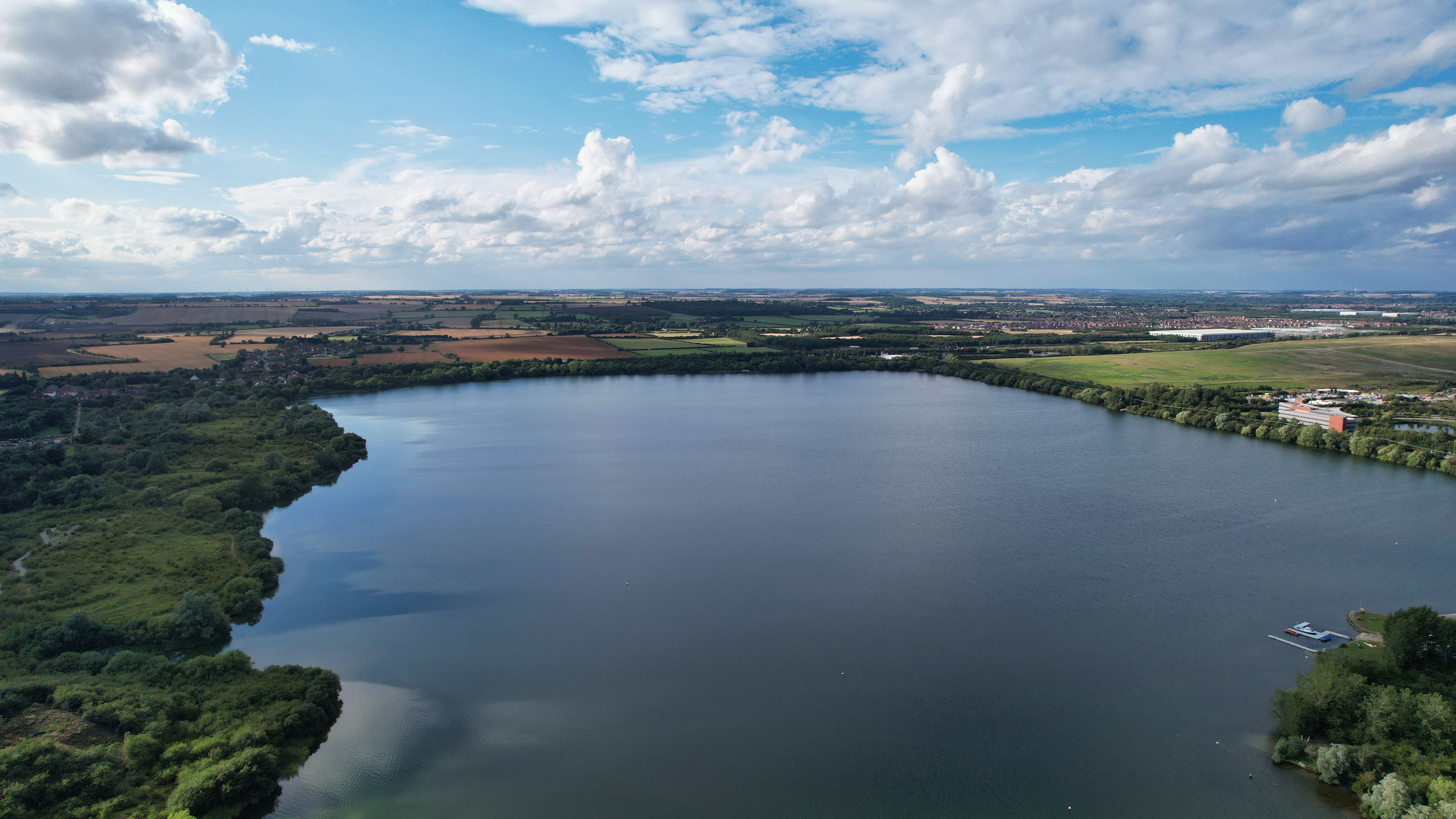Green Grass Field Beside Lake Under Blue Sky and White Clouds · Free ...