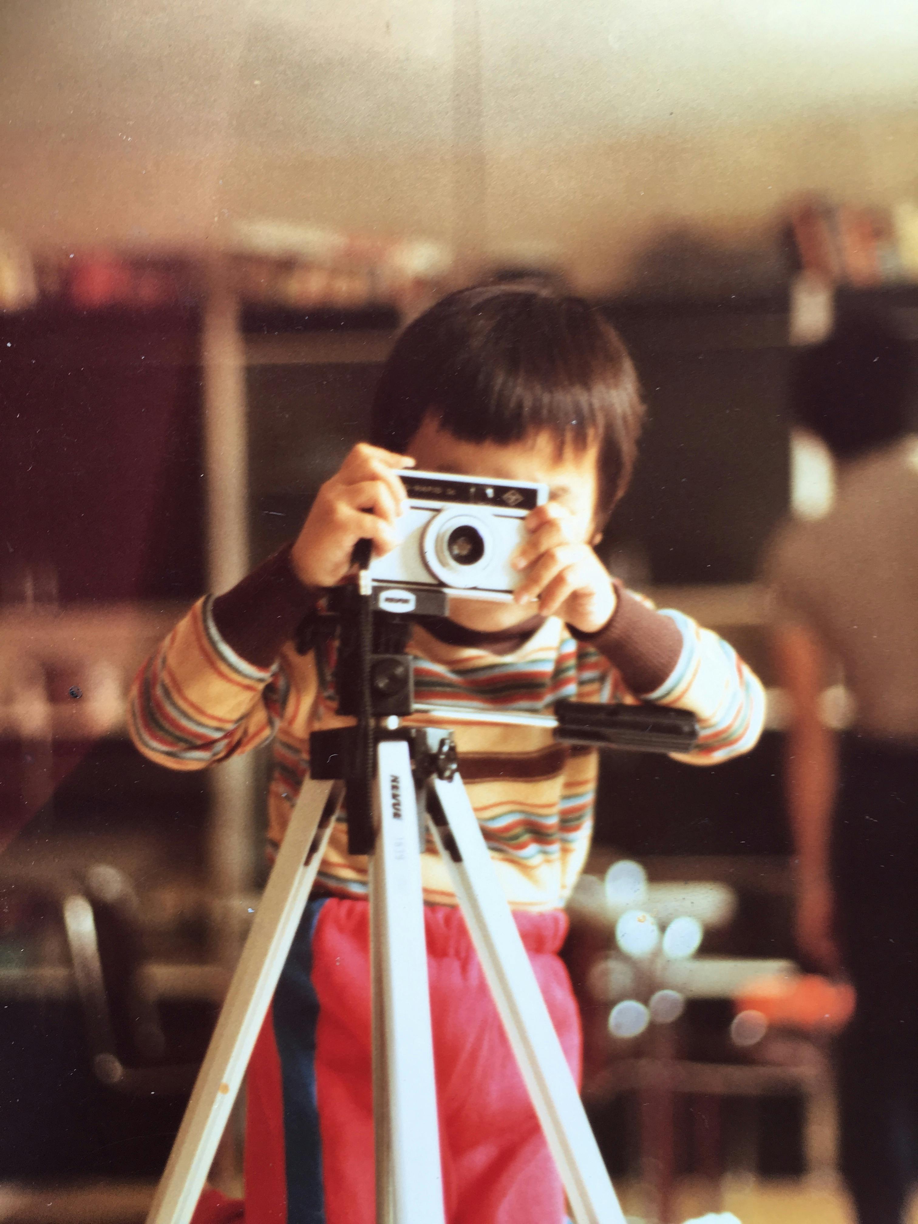 Boy Using Camera Near Green Leaf Plants · Free Stock Photo
