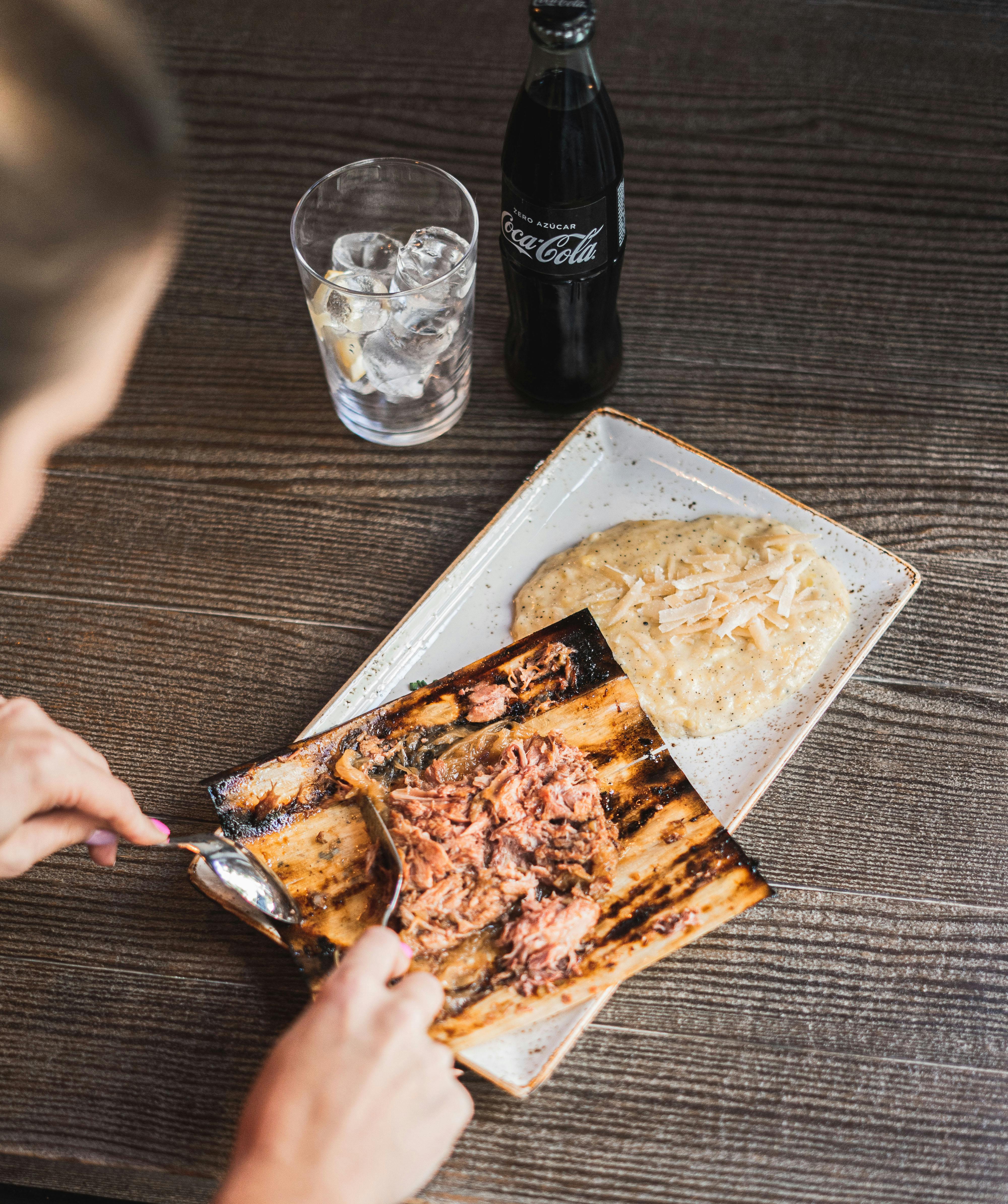 Woman Eating Dinner with Coca Cola · Free Stock Photo