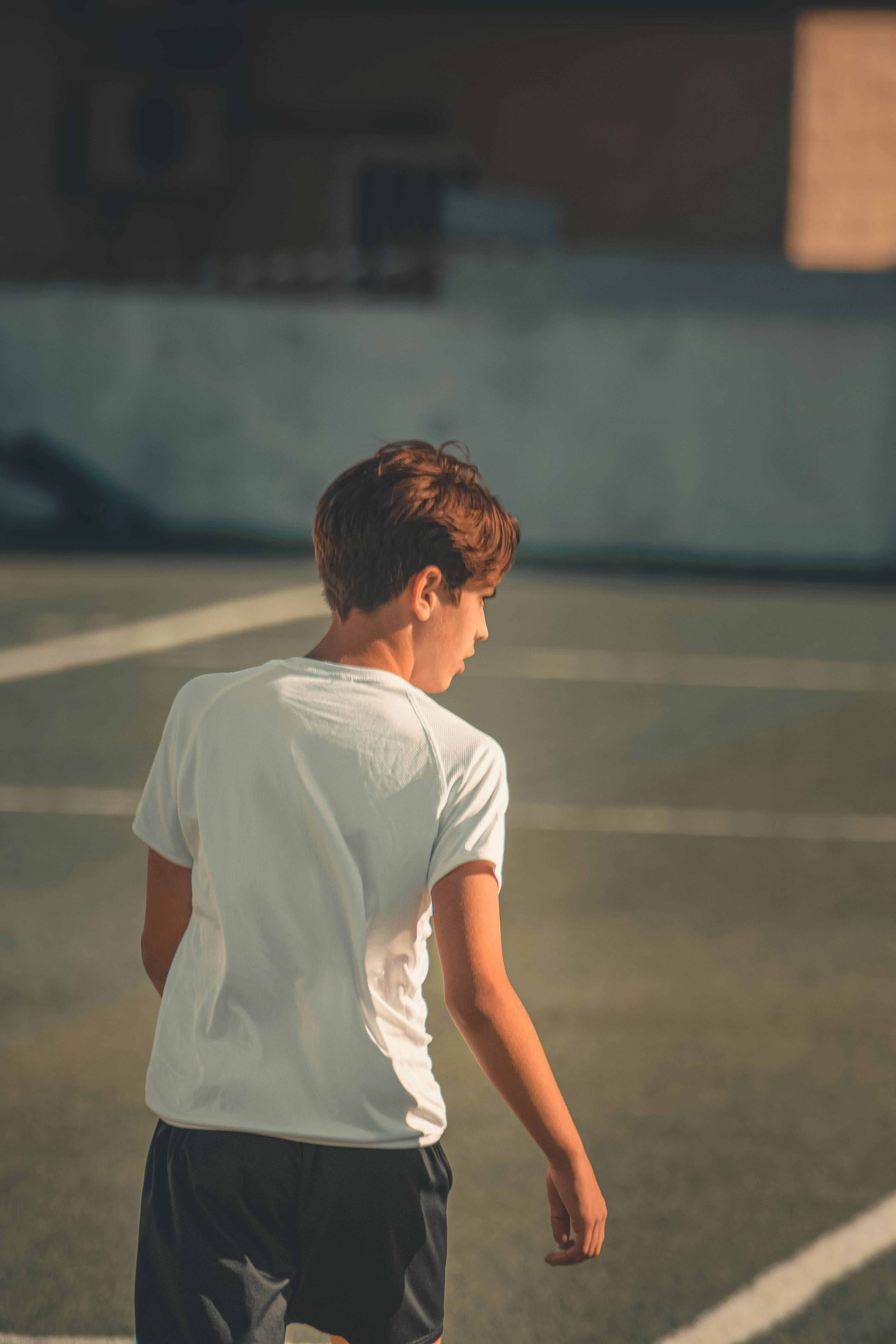 Side View of a Boy Kneeling on a Yellow Blanket · Free Stock Photo