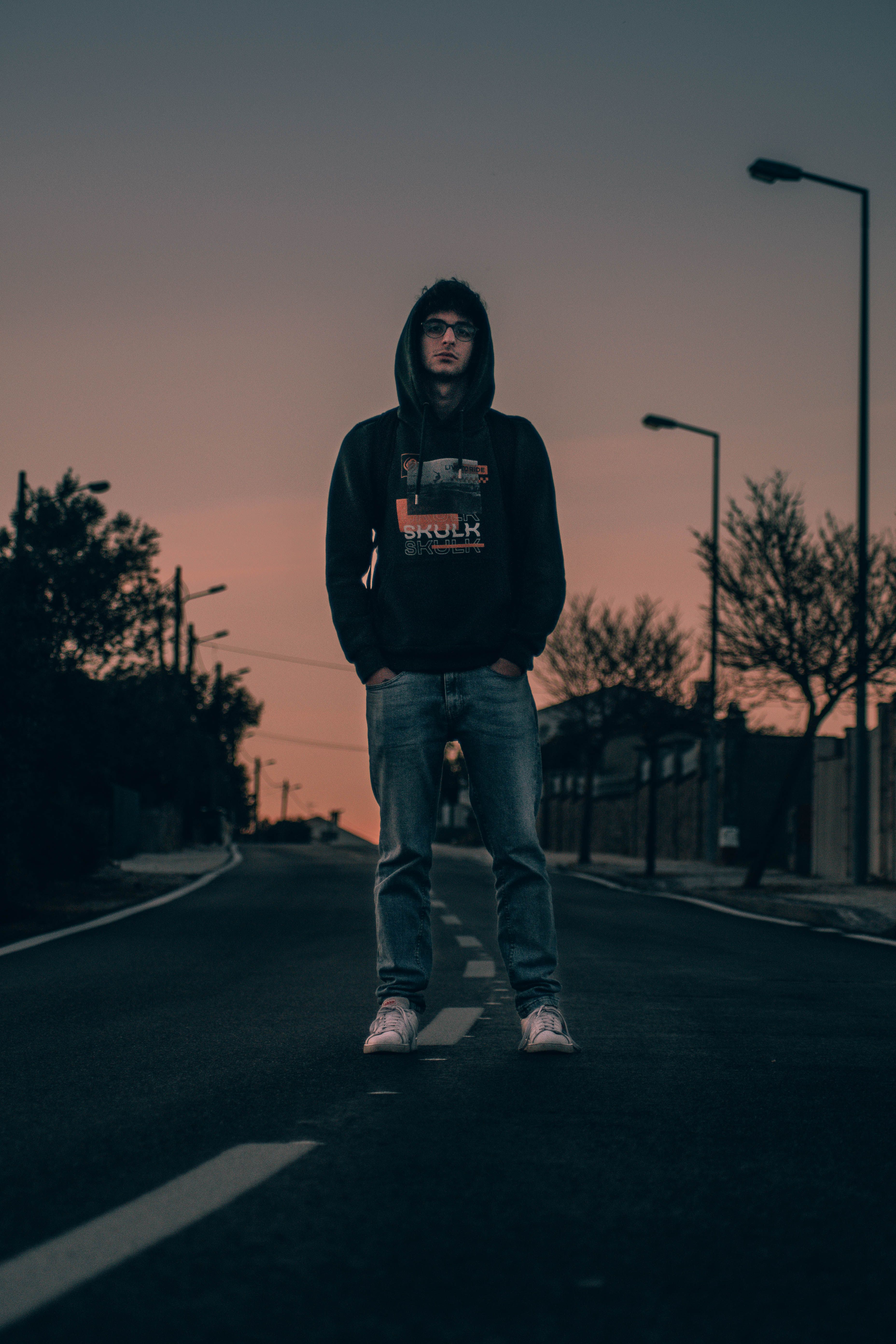 man standing alone in dark with hoodie and hat · Free Stock Photo