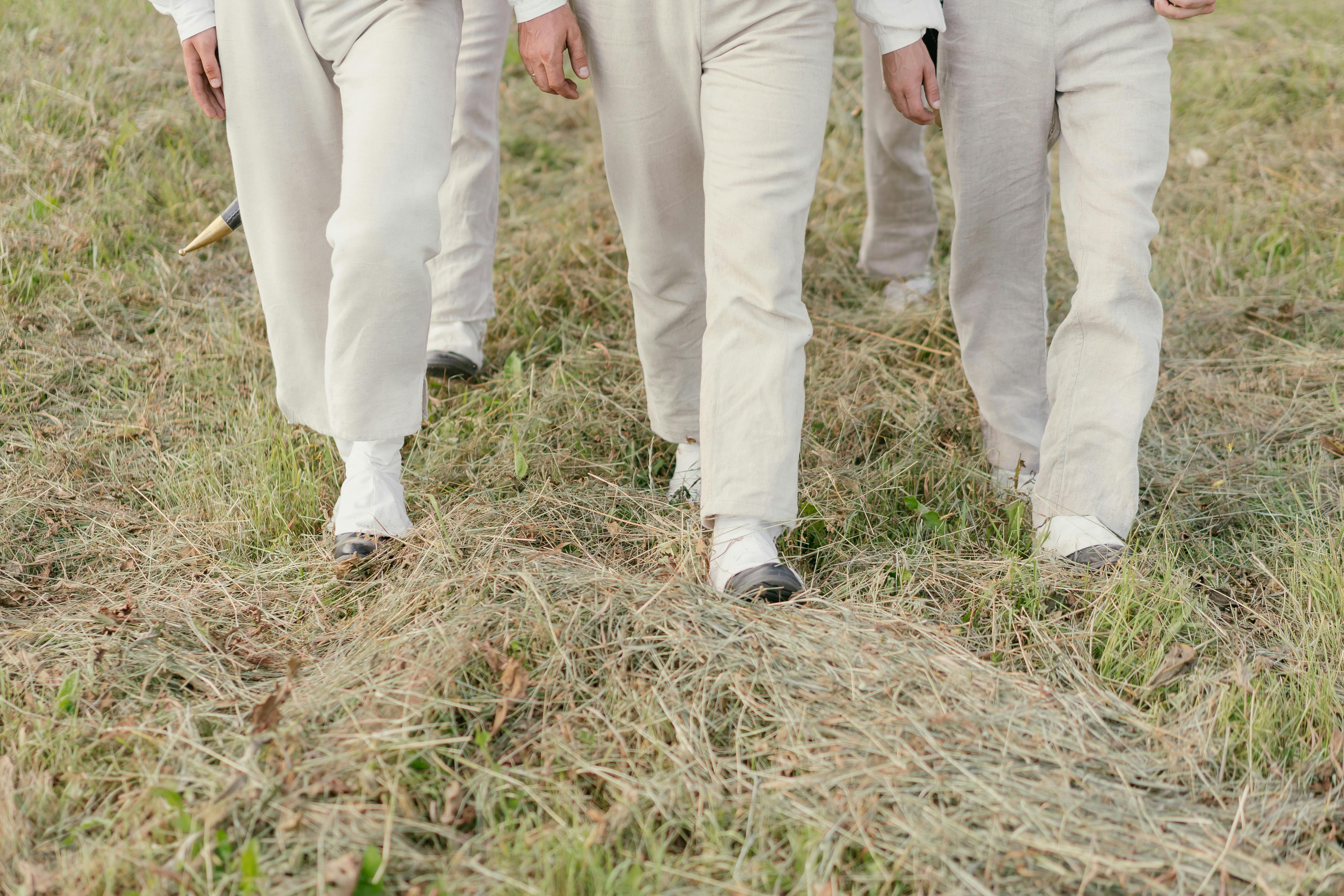 A Group of People Walking on Grass Field · Free Stock Photo