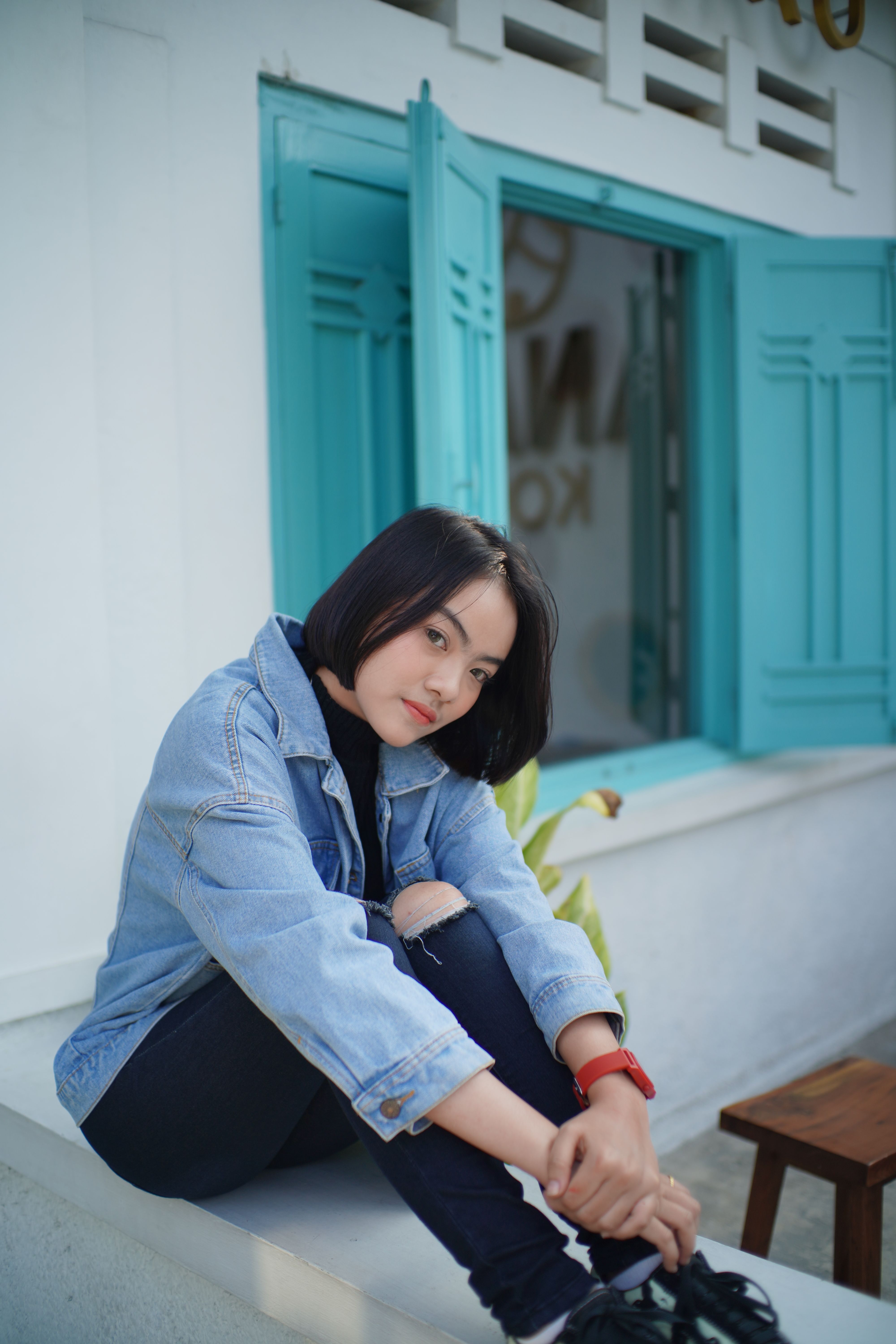A Woman Wearing a Scarf Sitting on a Ledge · Free Stock Photo