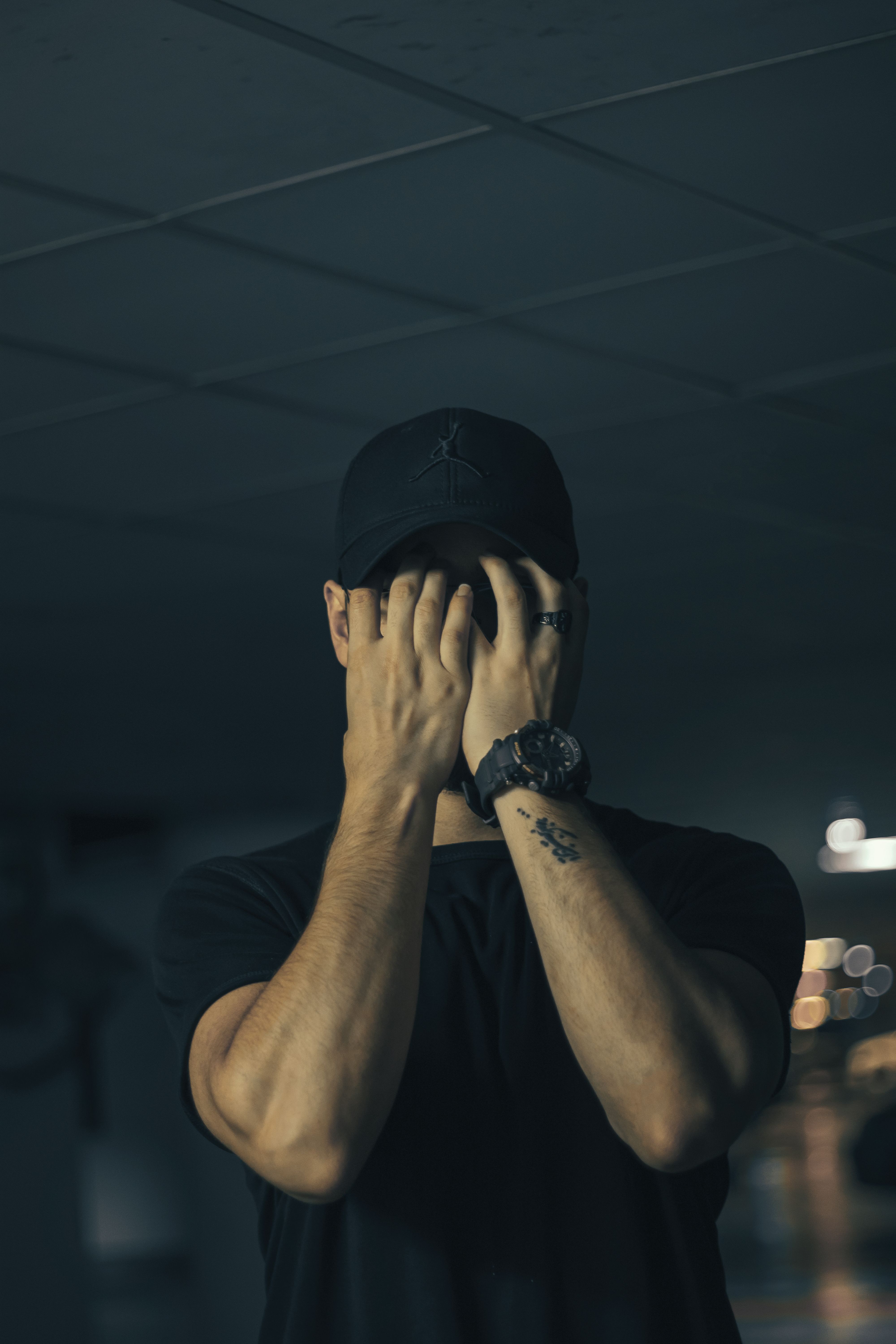 Man in Black Tank Top Wearing Black Cap Covering Face · Free Stock Photo