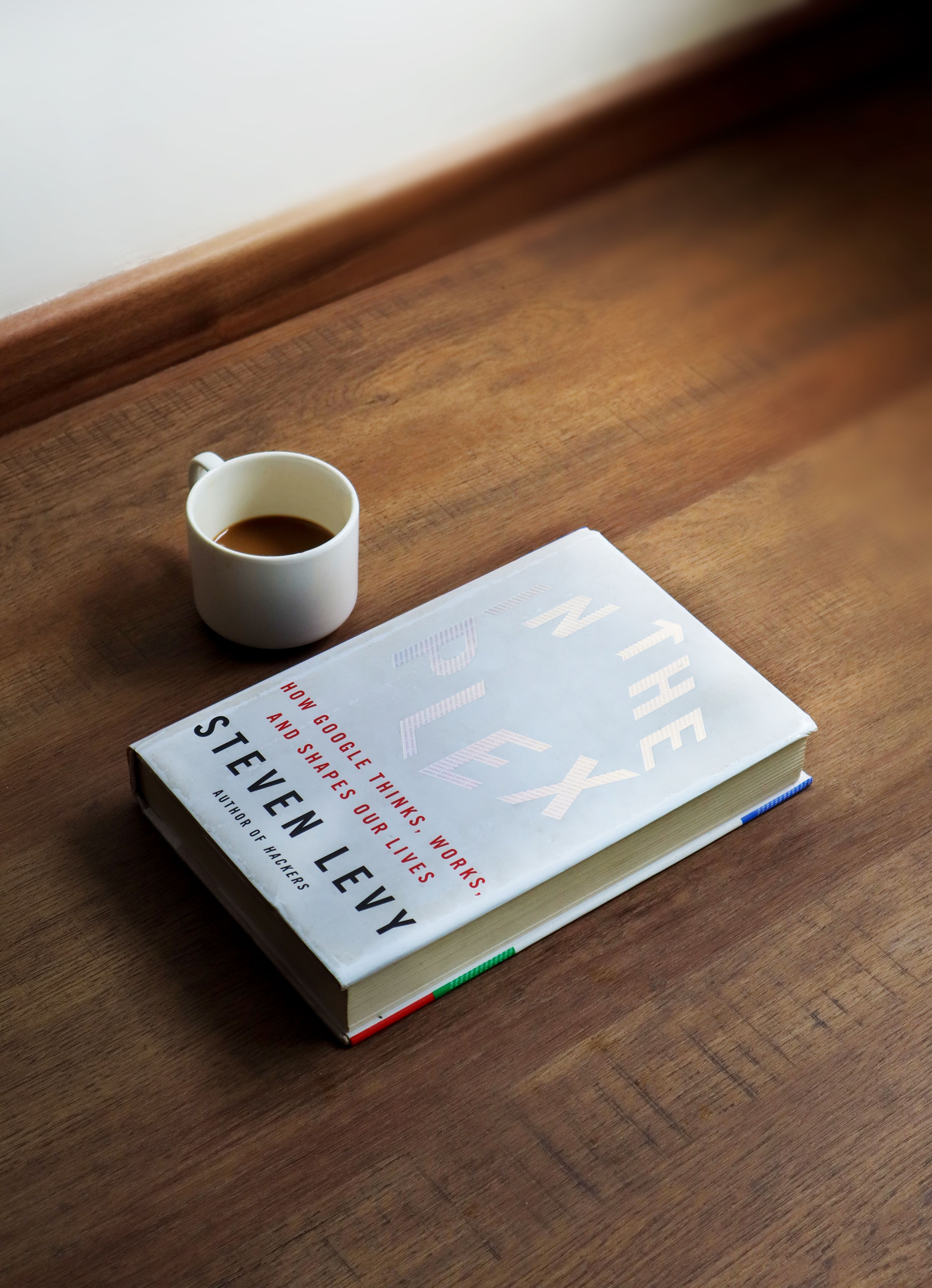 Book and Cup of Coffee on Wooden Surface · Free Stock Photo