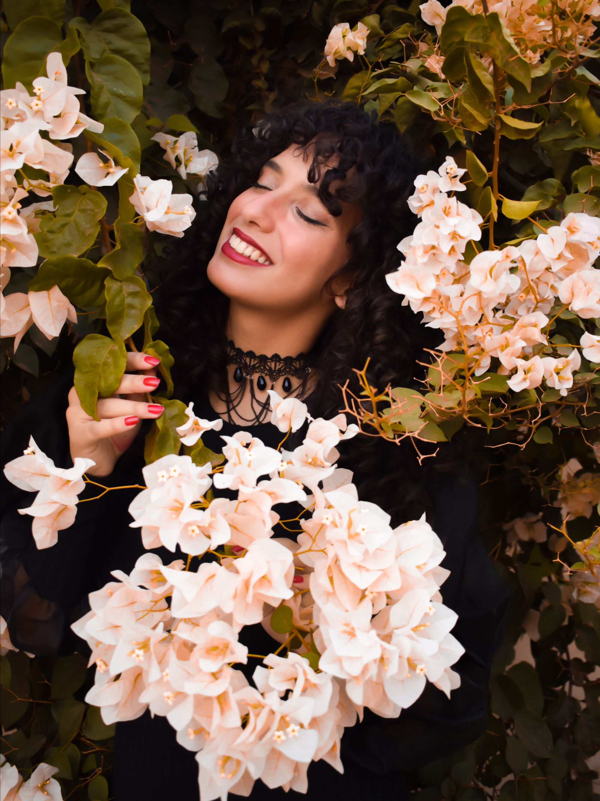 A Woman Standing in the Garden with Flowers Covering Her Face · Free ...