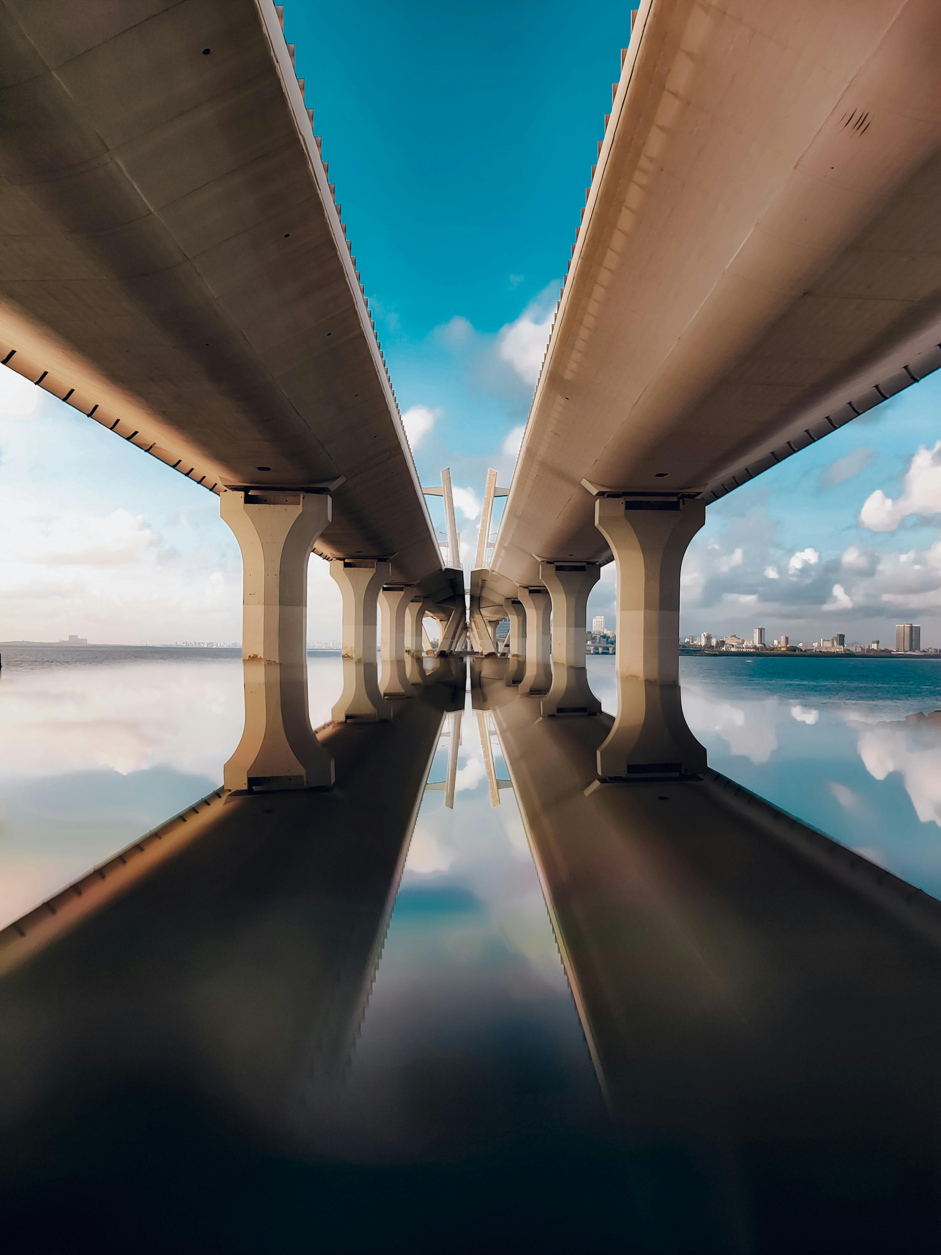 Symmetrical View and Reflection of a Modern Bridge and City in Distance ...