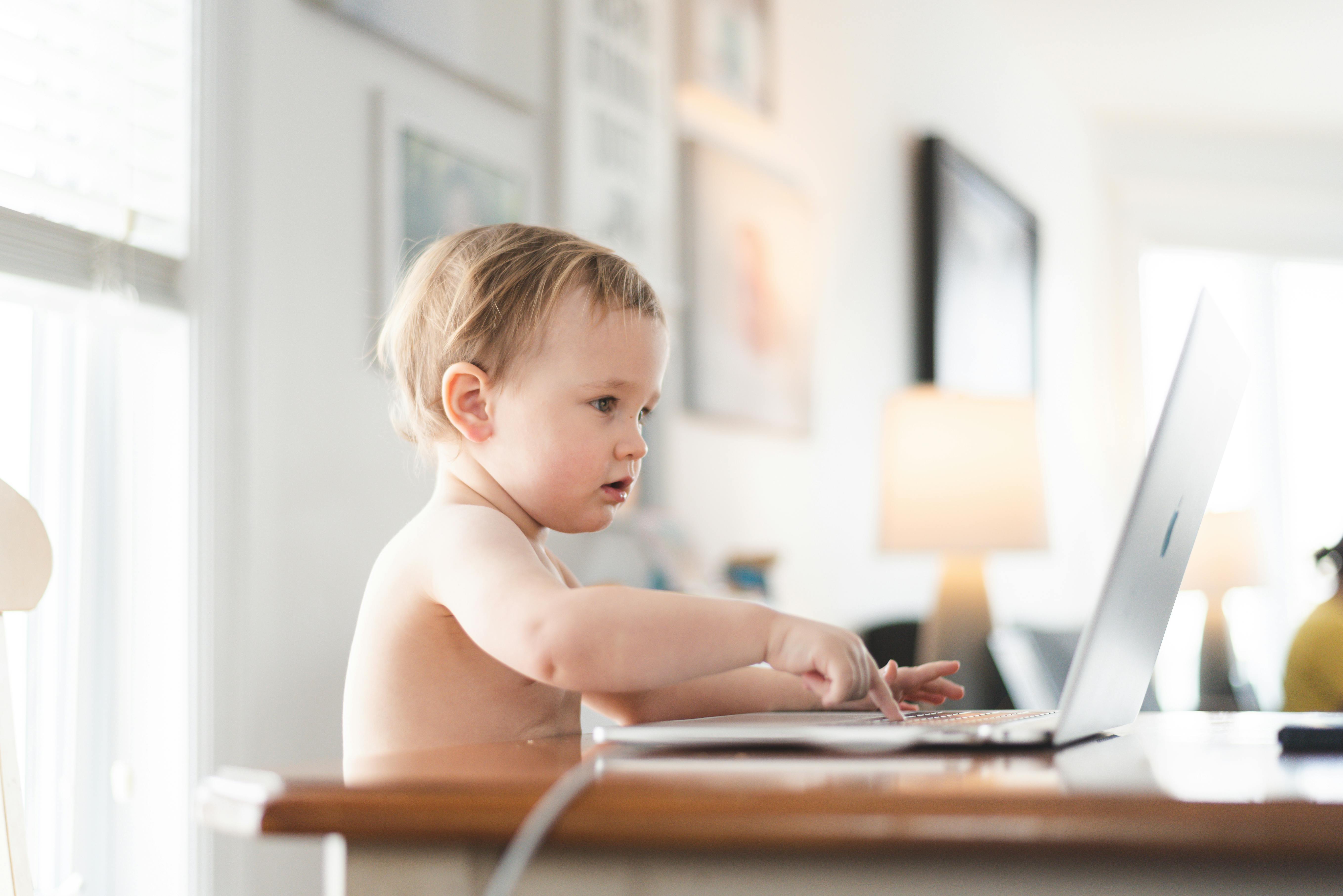 Photo of a Baby Using a Laptop · Free Stock Photo