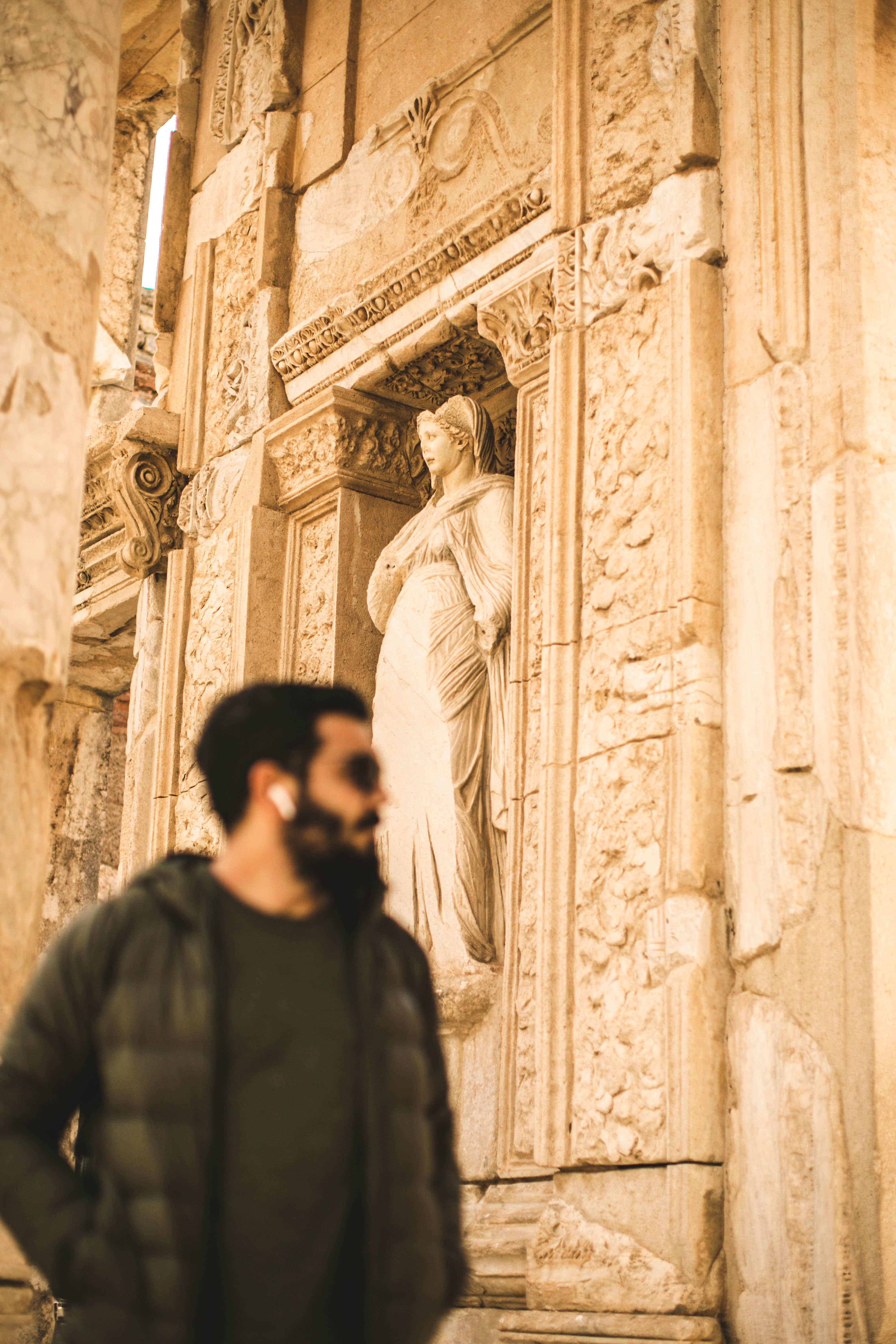 Ancient Statue on Pedestal on Yellow Wall Background · Free Stock Photo