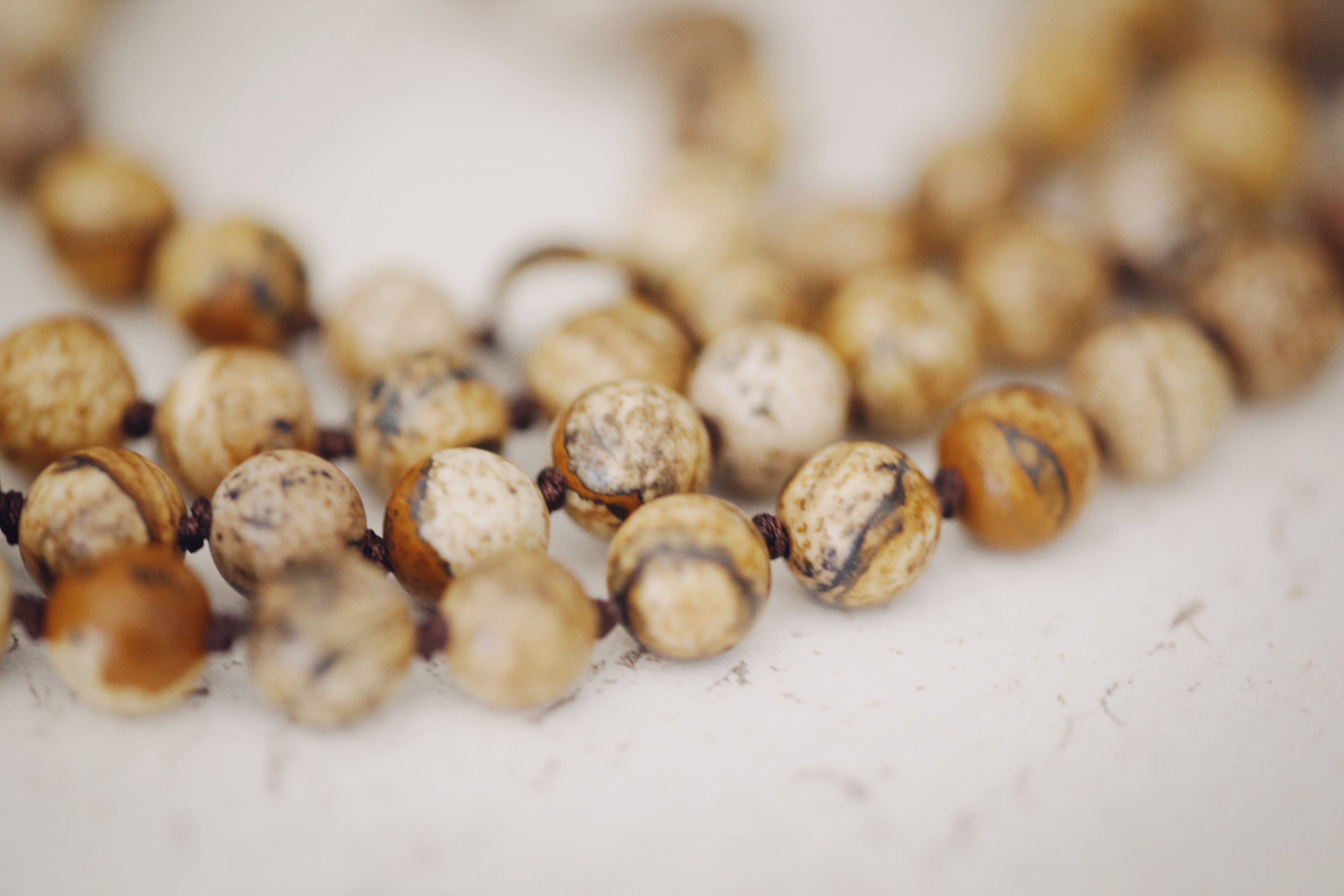 Extreme Close-Up Shot of Brown Beads on White Surface · Free Stock Photo